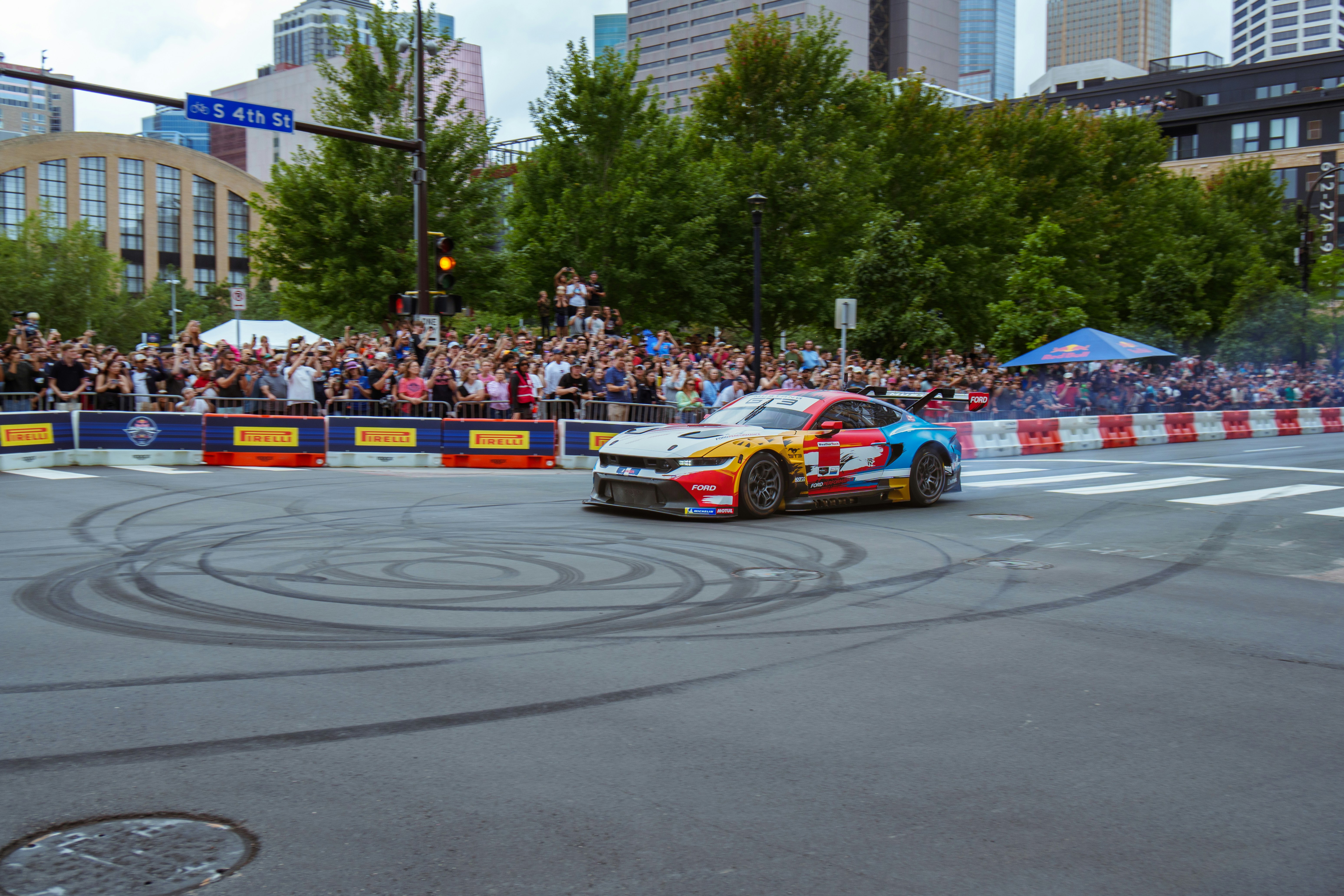 A car driving down a race track with a crowd watching photo – Free ...