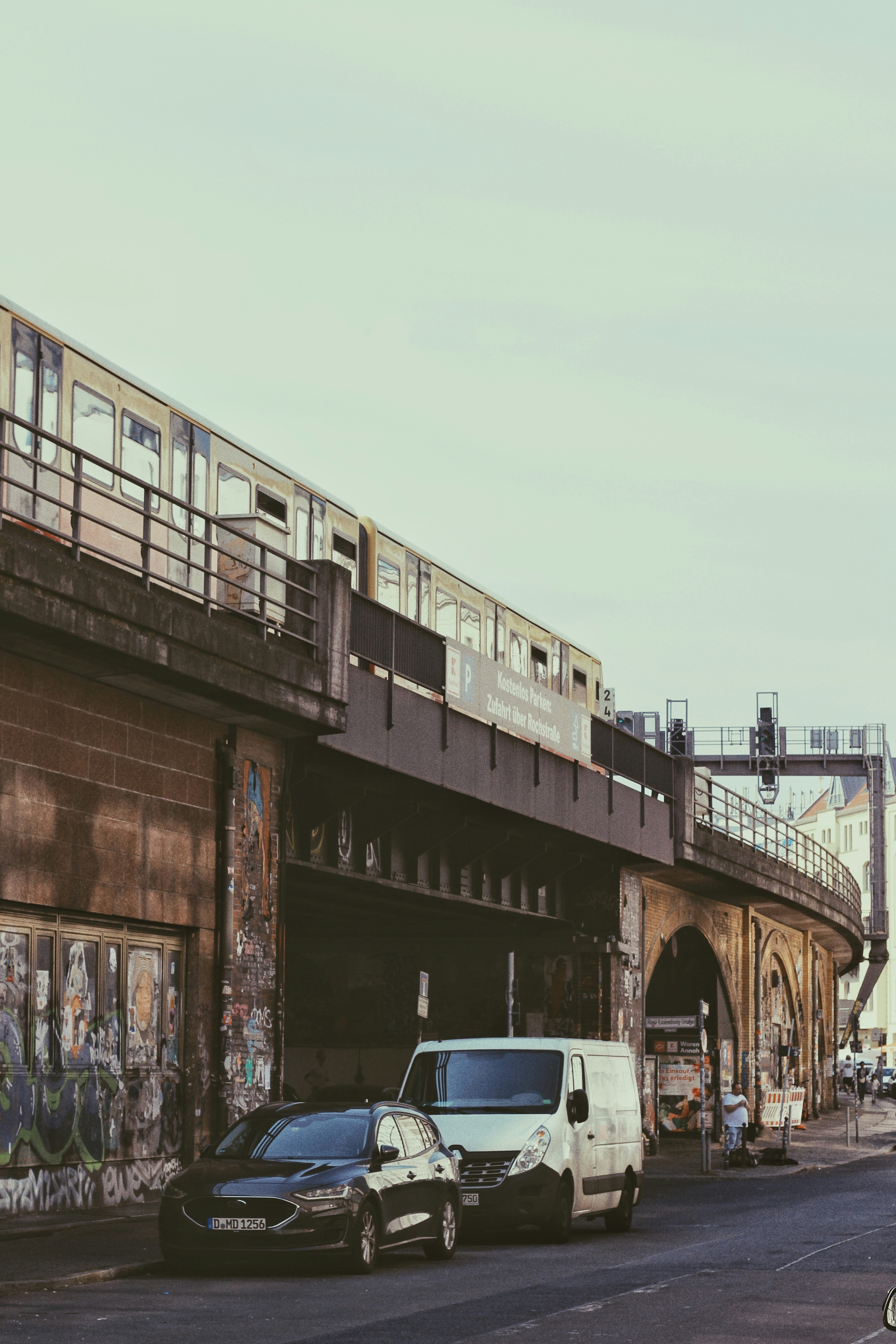 Overpass Afterglow: Street Scene Beneath a Graffitied Rail Bridge