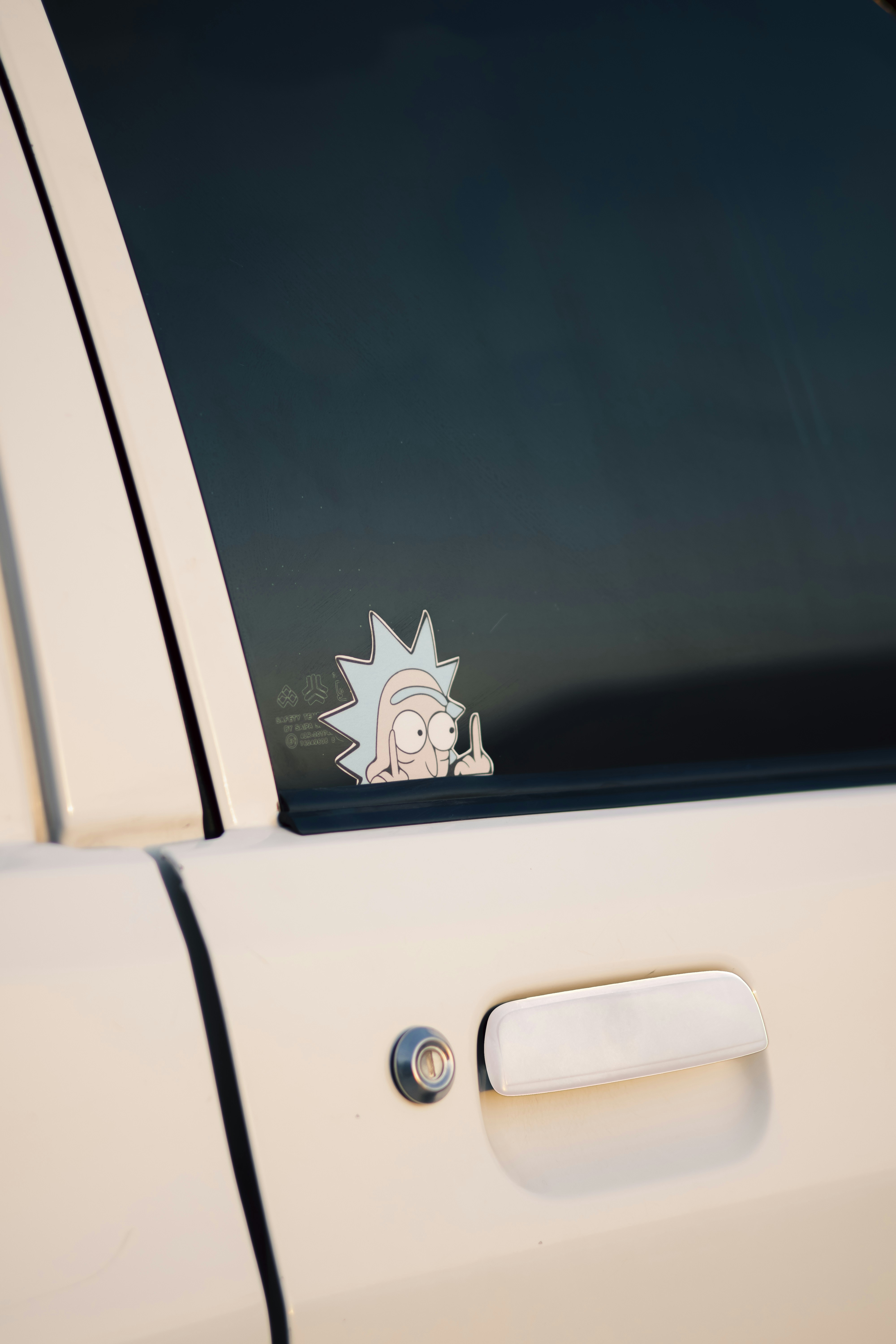 Rick on Glass: A Tiny Cartoon Rebel on a White Sedan
