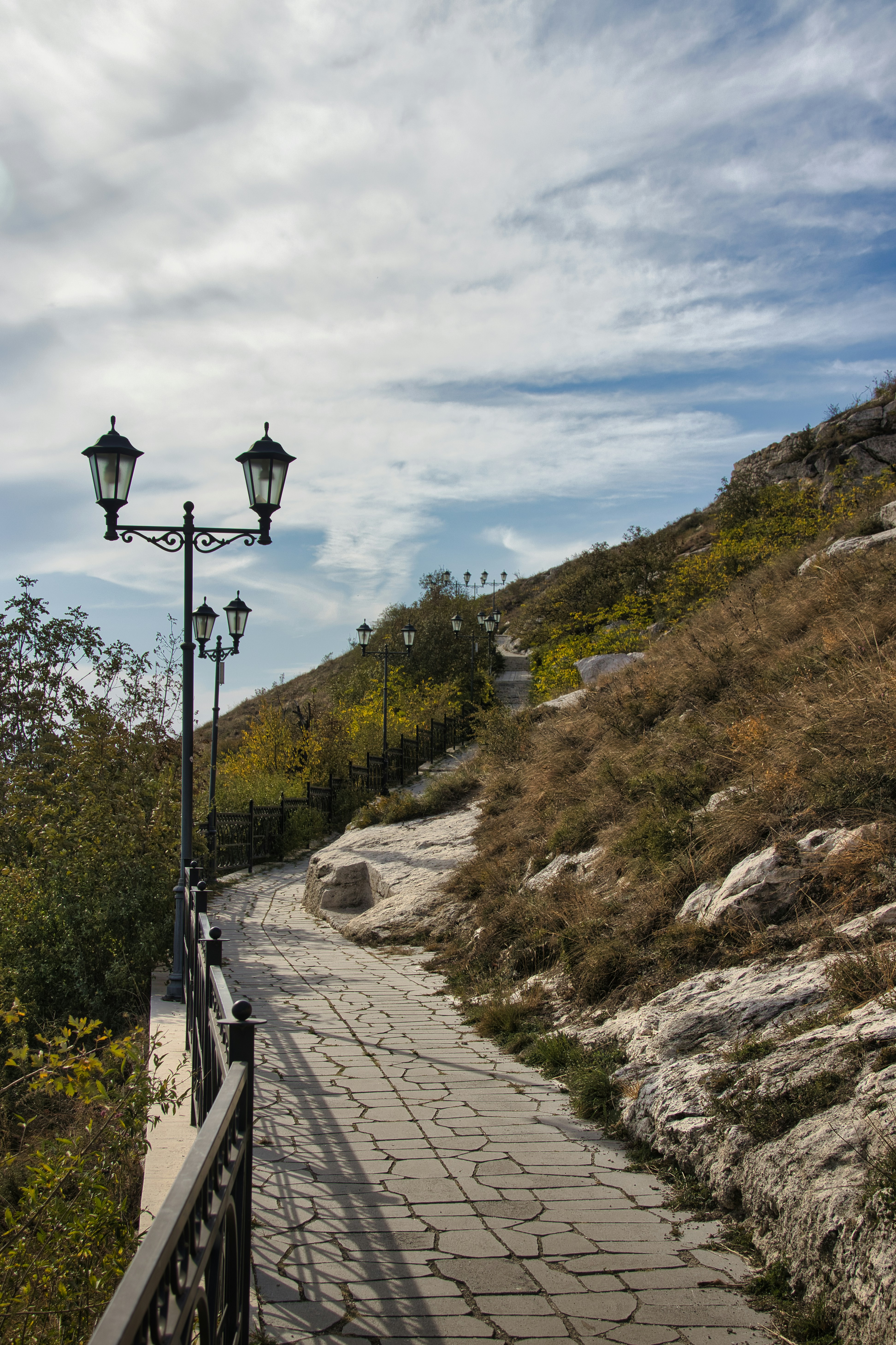 A stone path leading up a hill to a light pole photo – Free Path Image ...