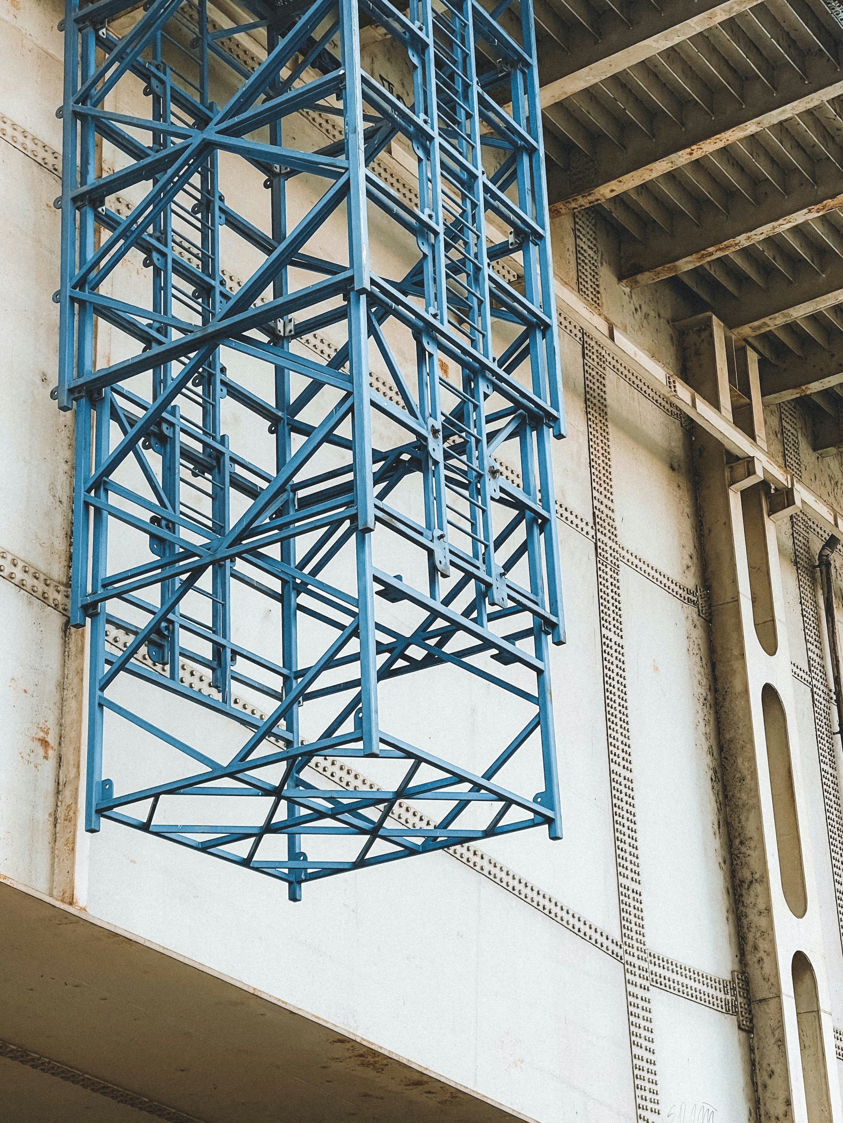 A blue scaffold hanging from the side of a building photo – Free ...