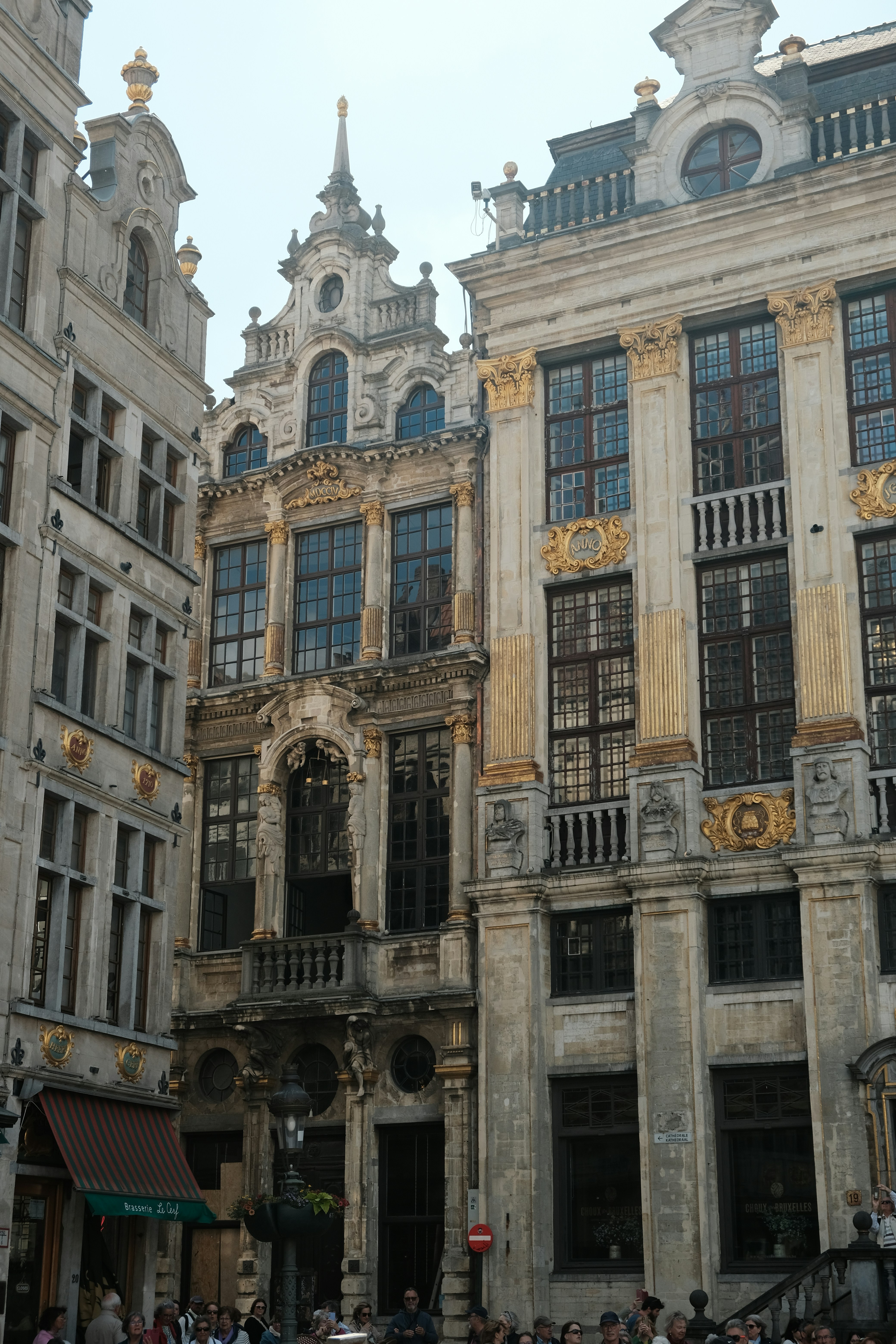 A group of people walking around a large building photo – Free ...