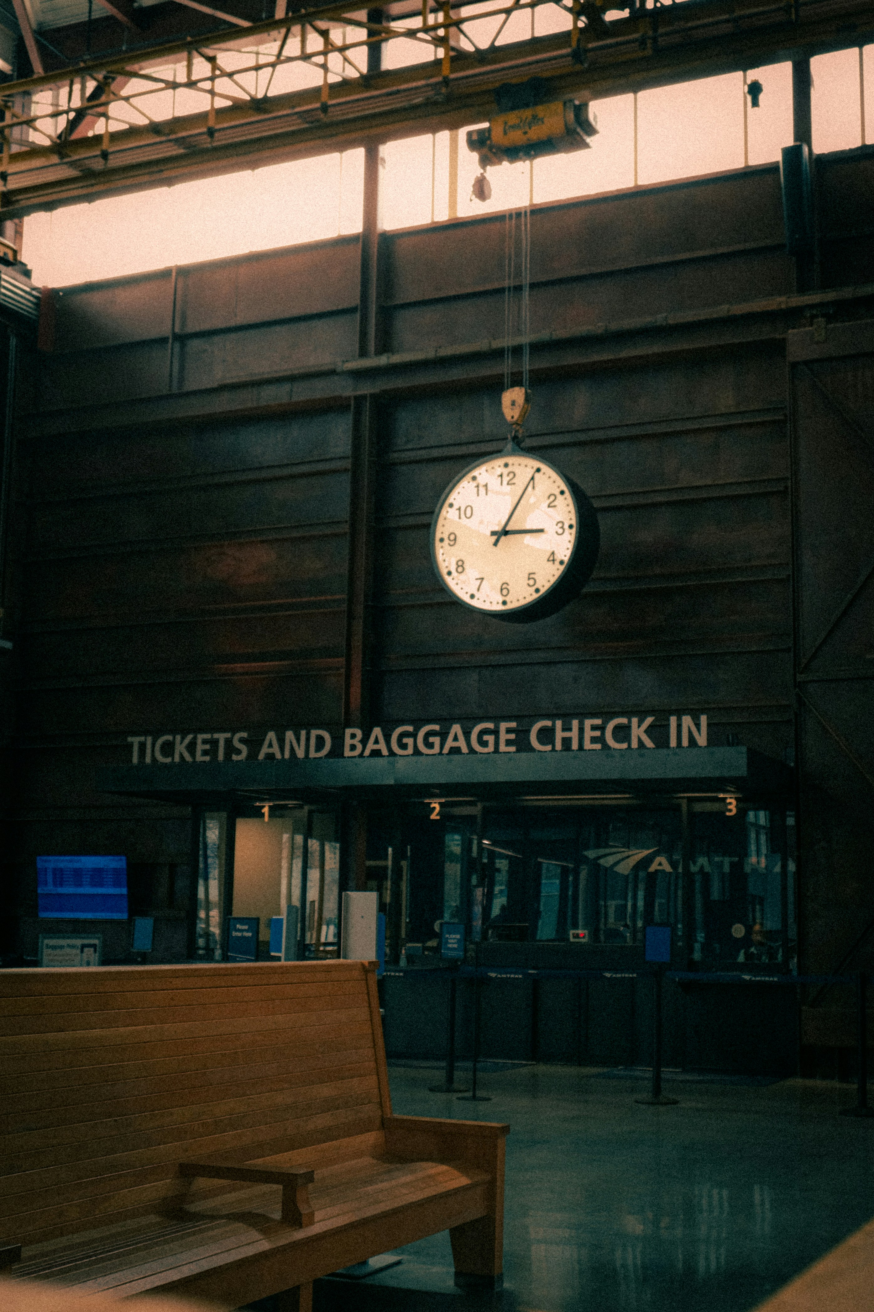 A large clock hanging from the ceiling of a building