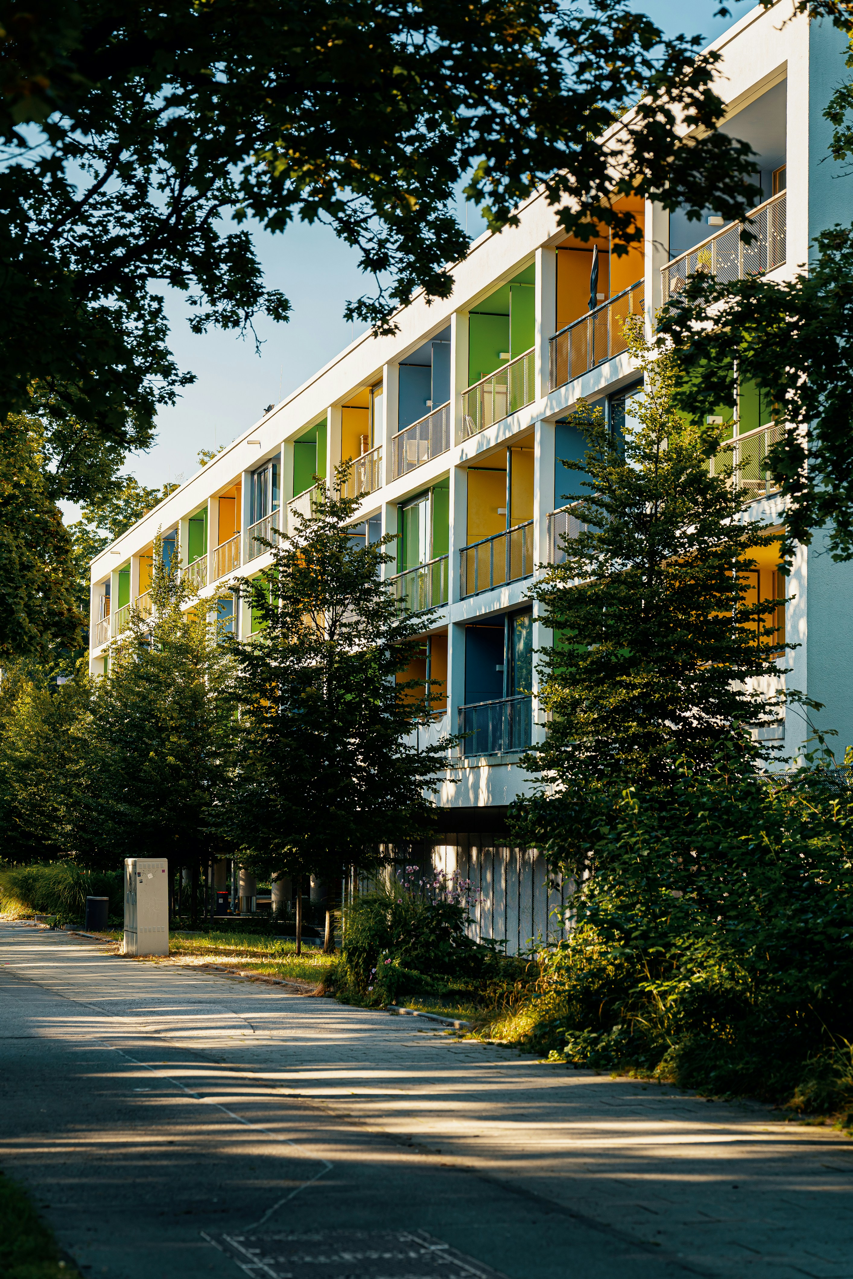Rainbow Balconies: Sunlit Corridor on a Modern Residential Façade