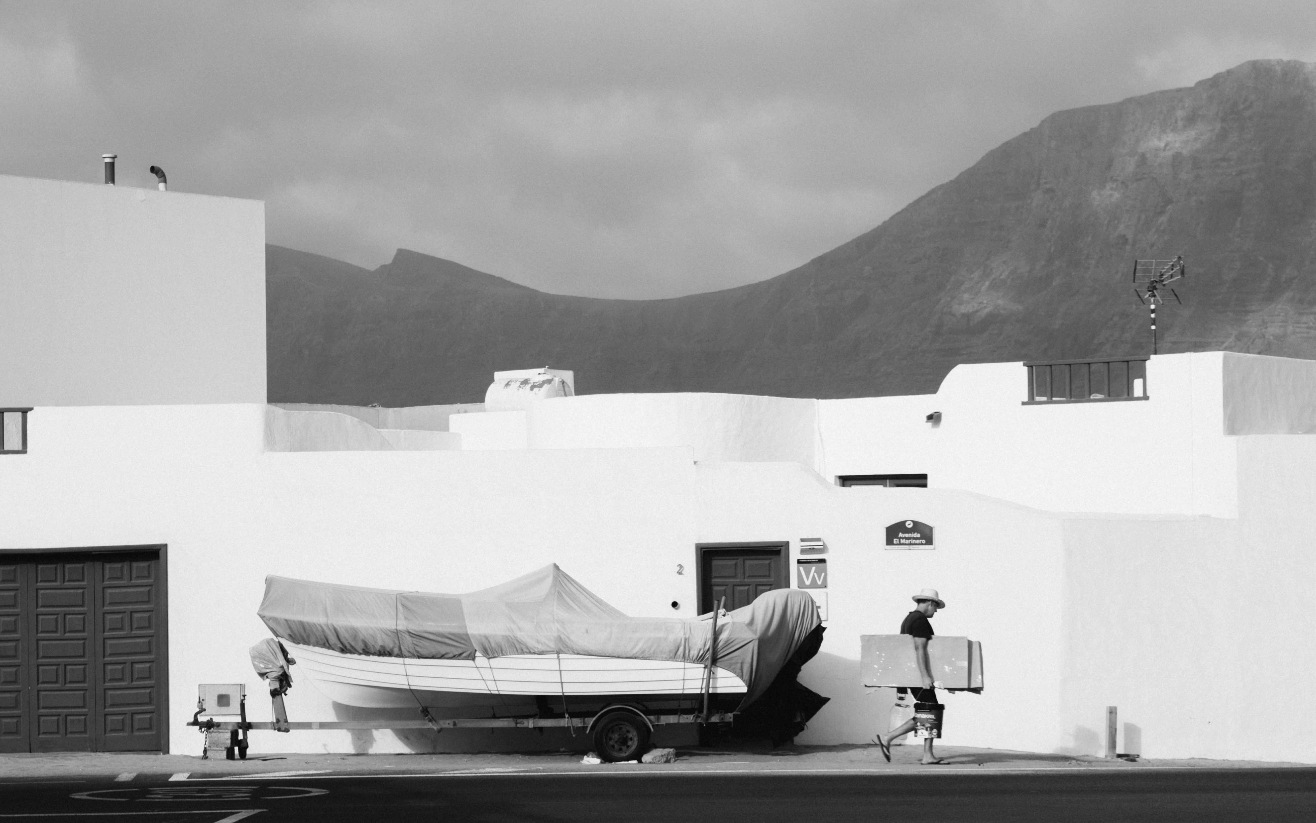 Tarped Boat on a Trailer Framed by White Walls and Distant Peaks