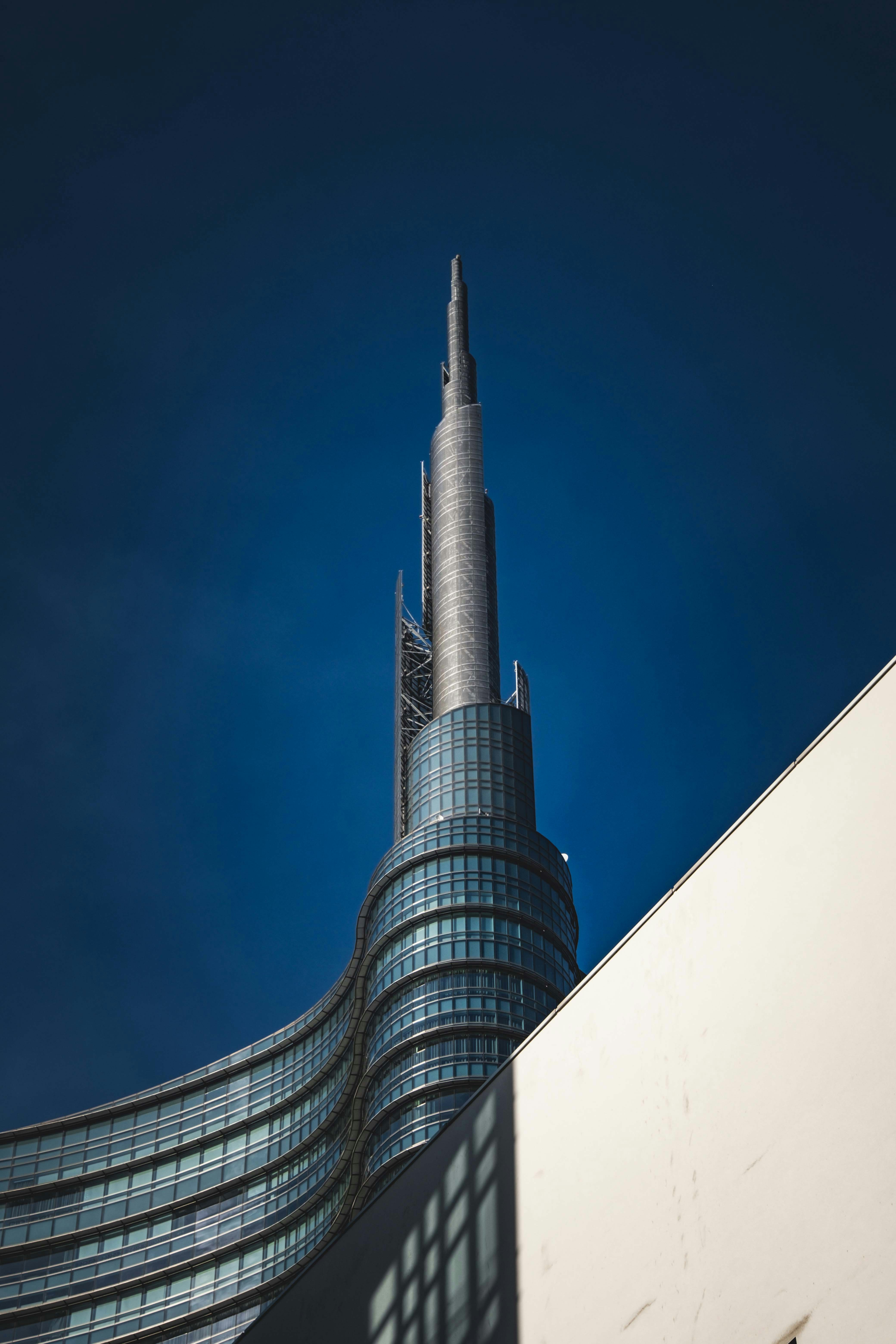 A very tall building towering over a city photo – Free Building Image ...