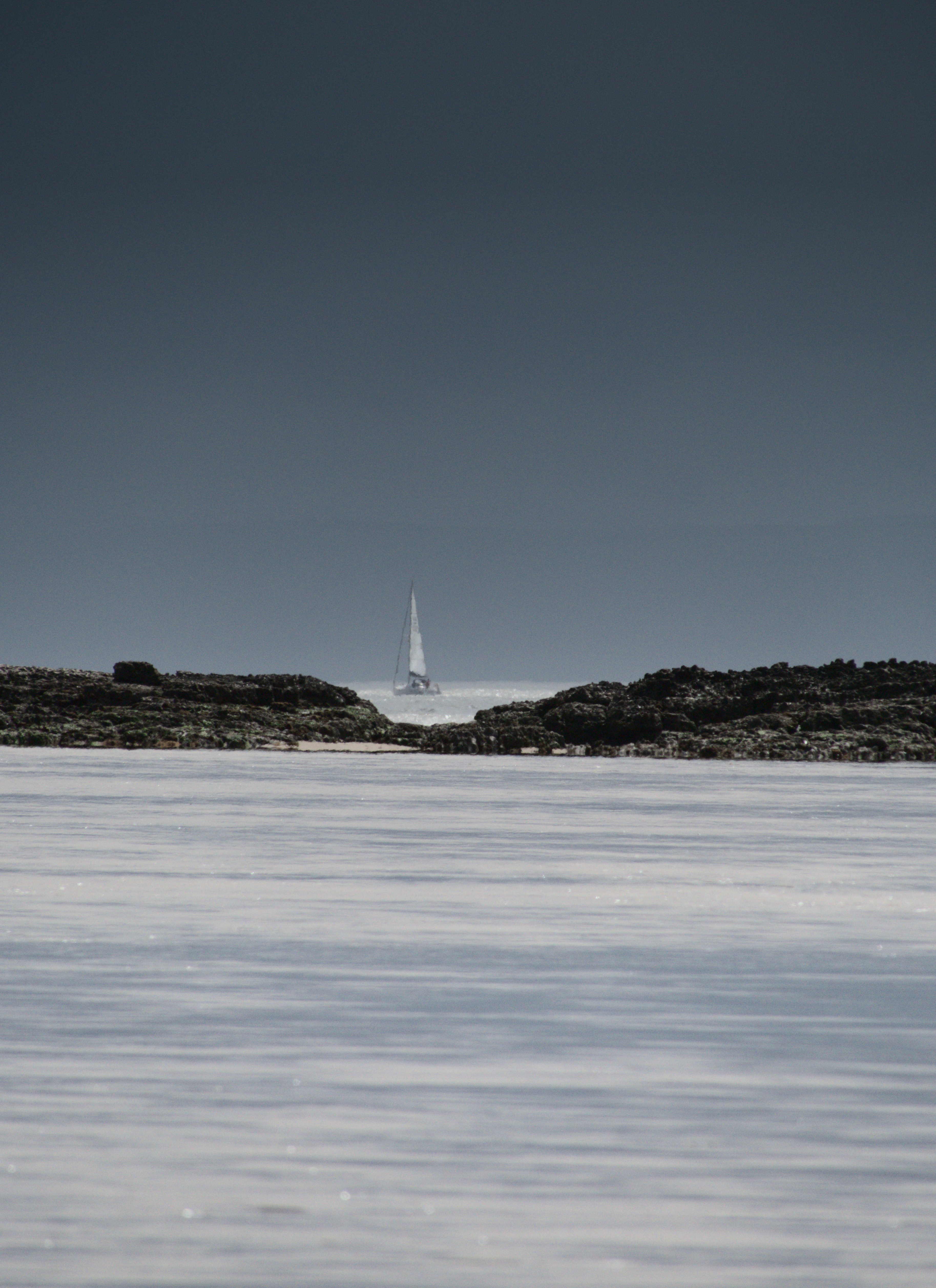 Horizon Sail on a Glassy Blue Sea