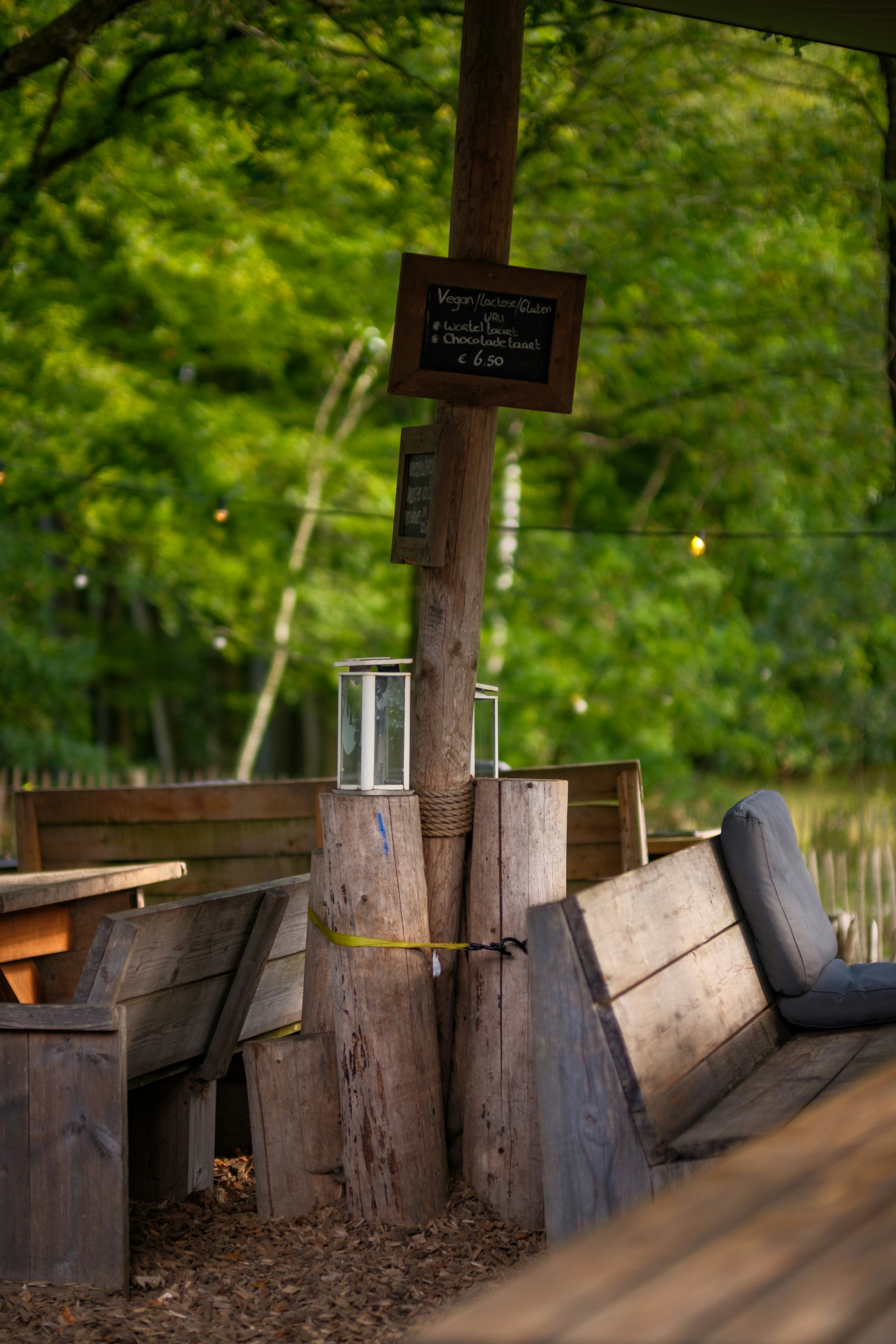 Chalkboard Centerpiece: Rustic Lakeside Seating Under a Green Canopy