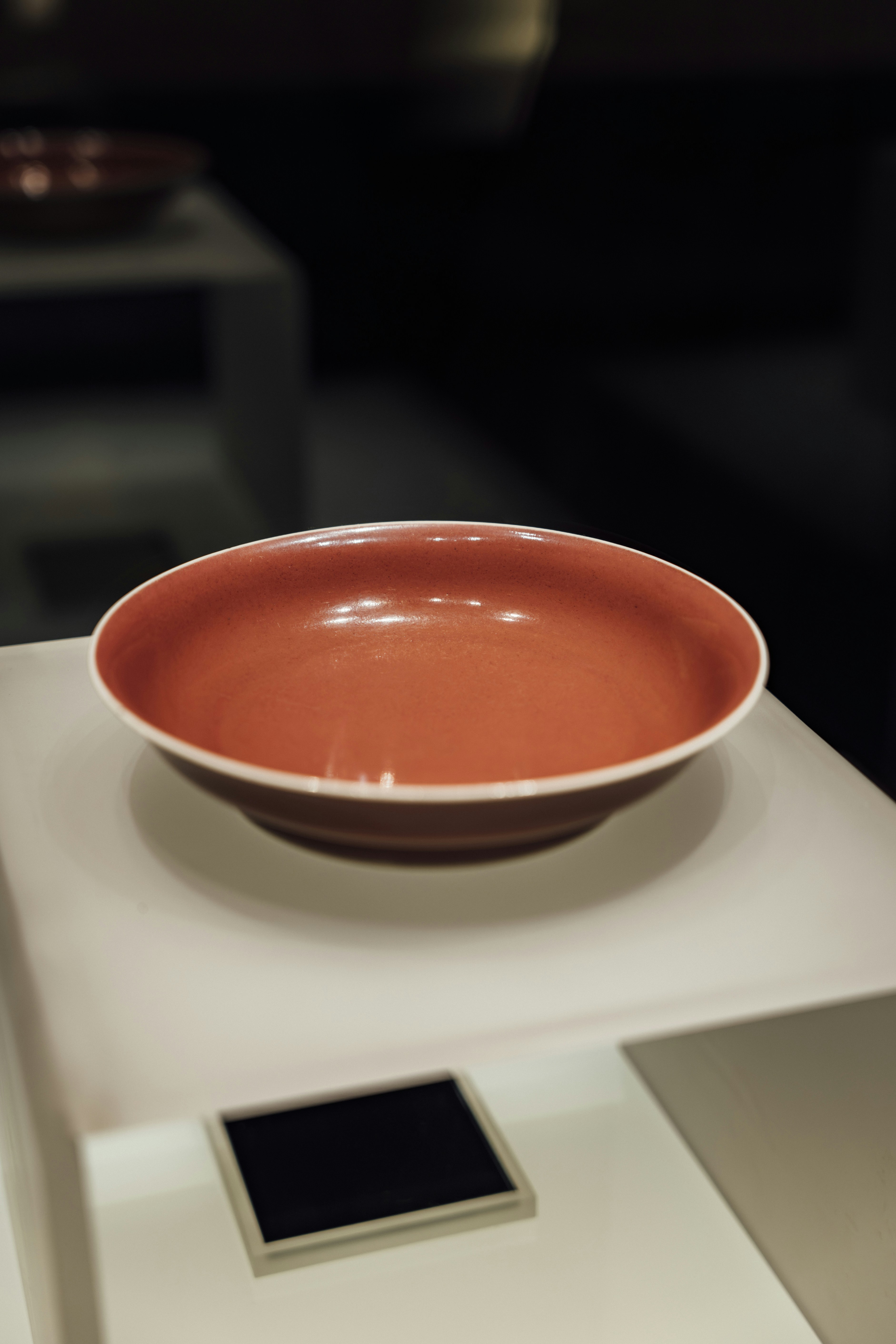 Terracotta Bowl on a White Pedestal Under Subtle Studio Lighting