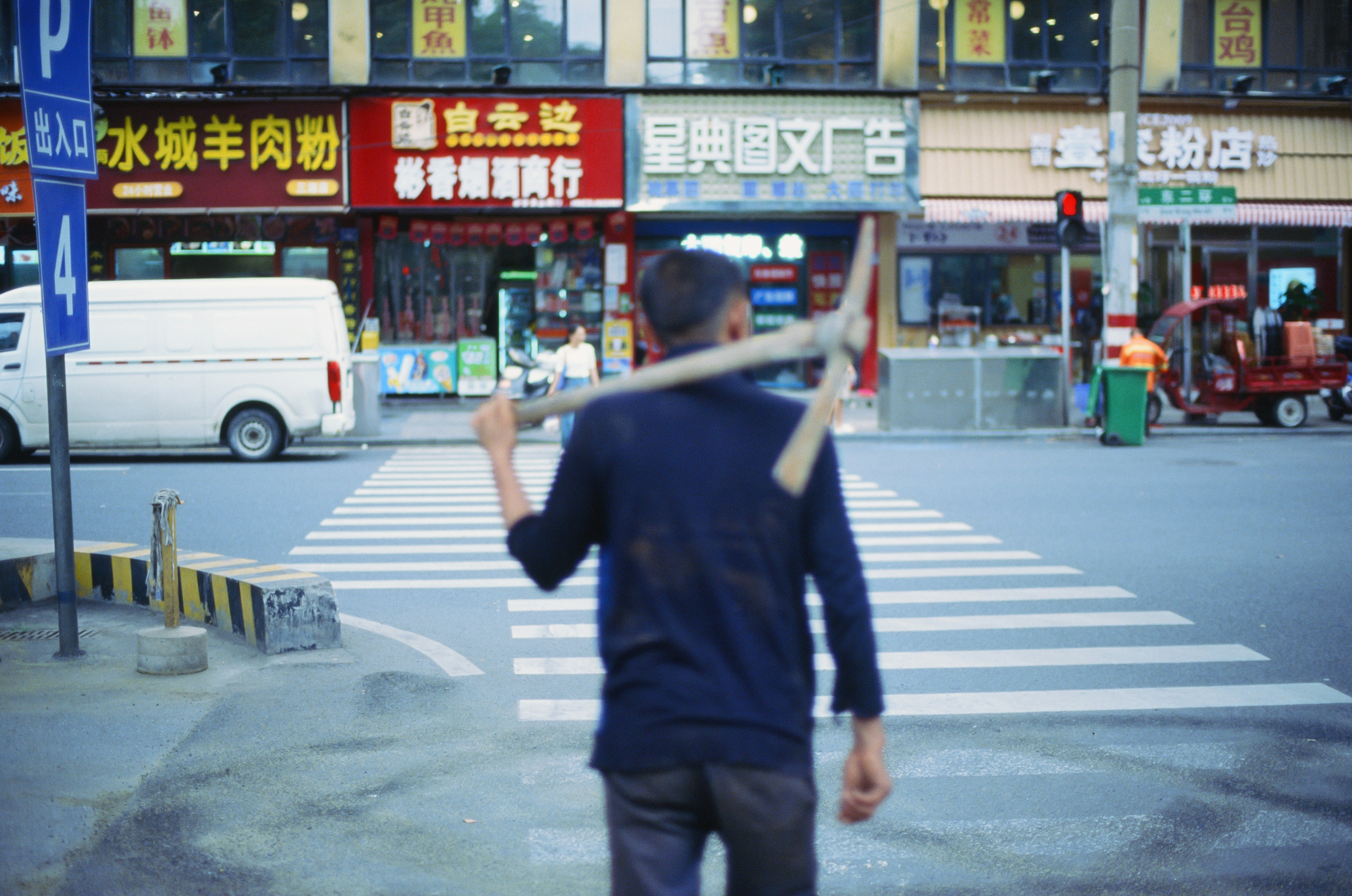 A man walking across a street holding a stick photo – Free Film ...