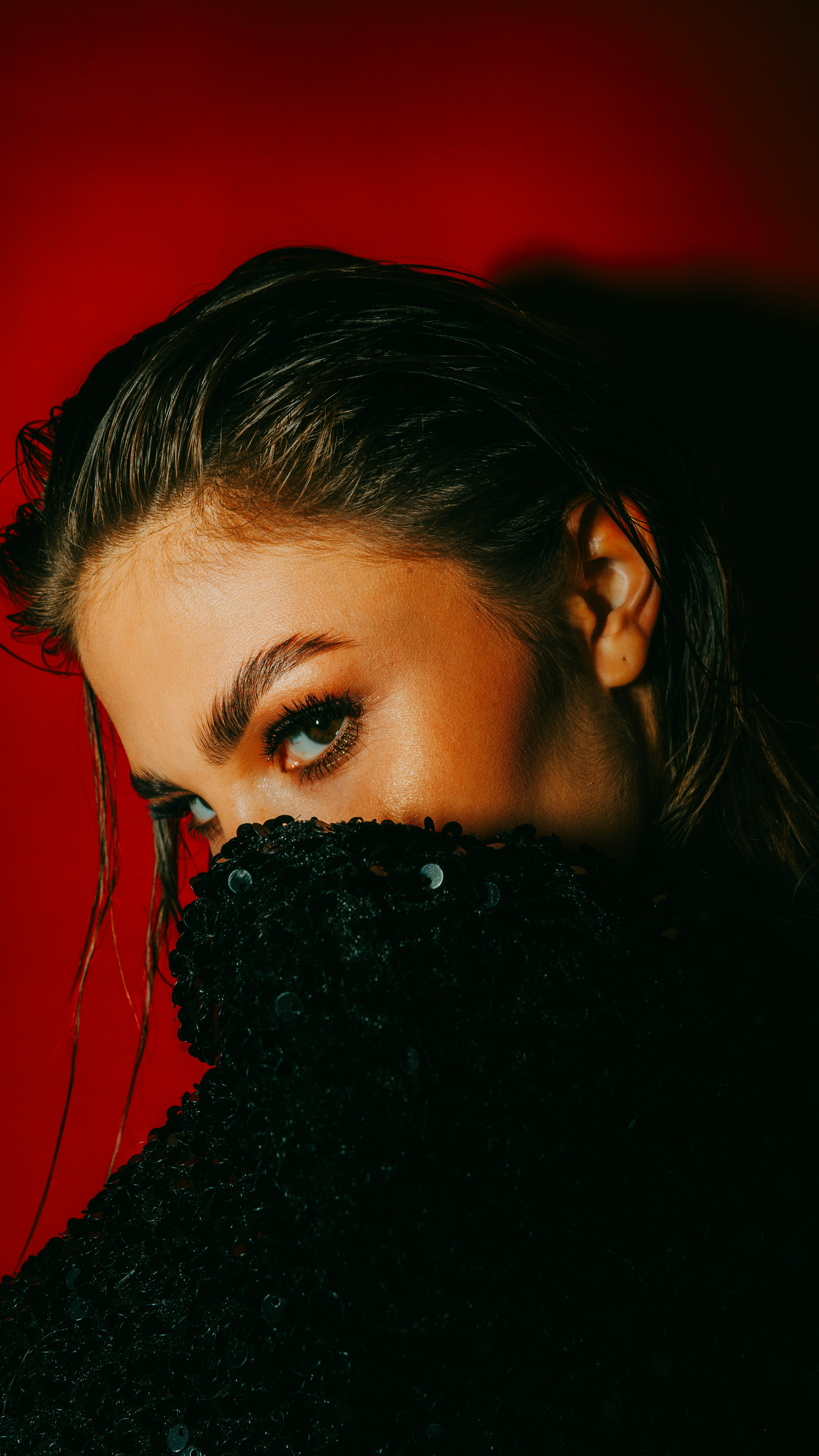 A woman with a black coat covering her face