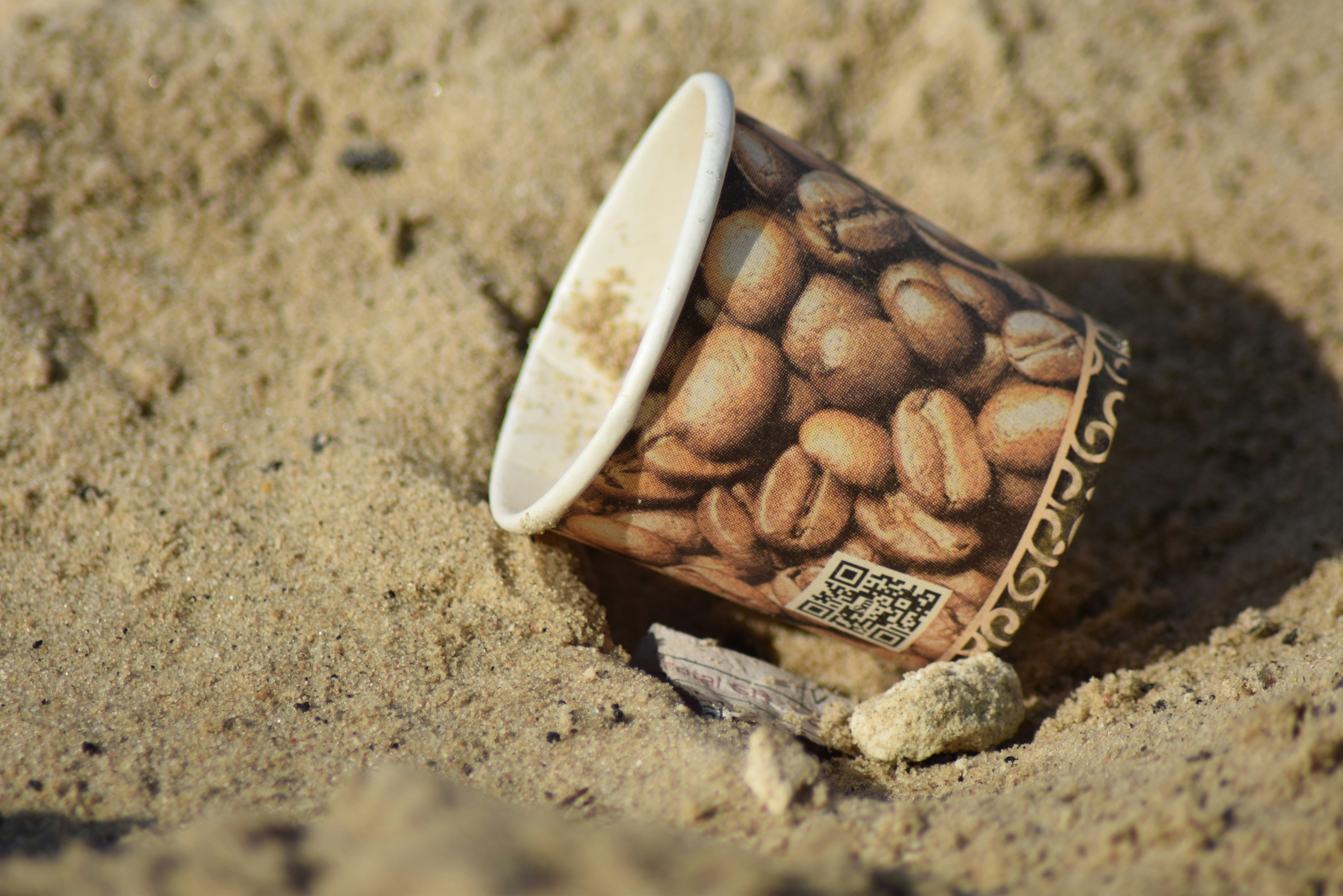 Coffee Cup Buried in Sand: A Moment of Quiet Detail