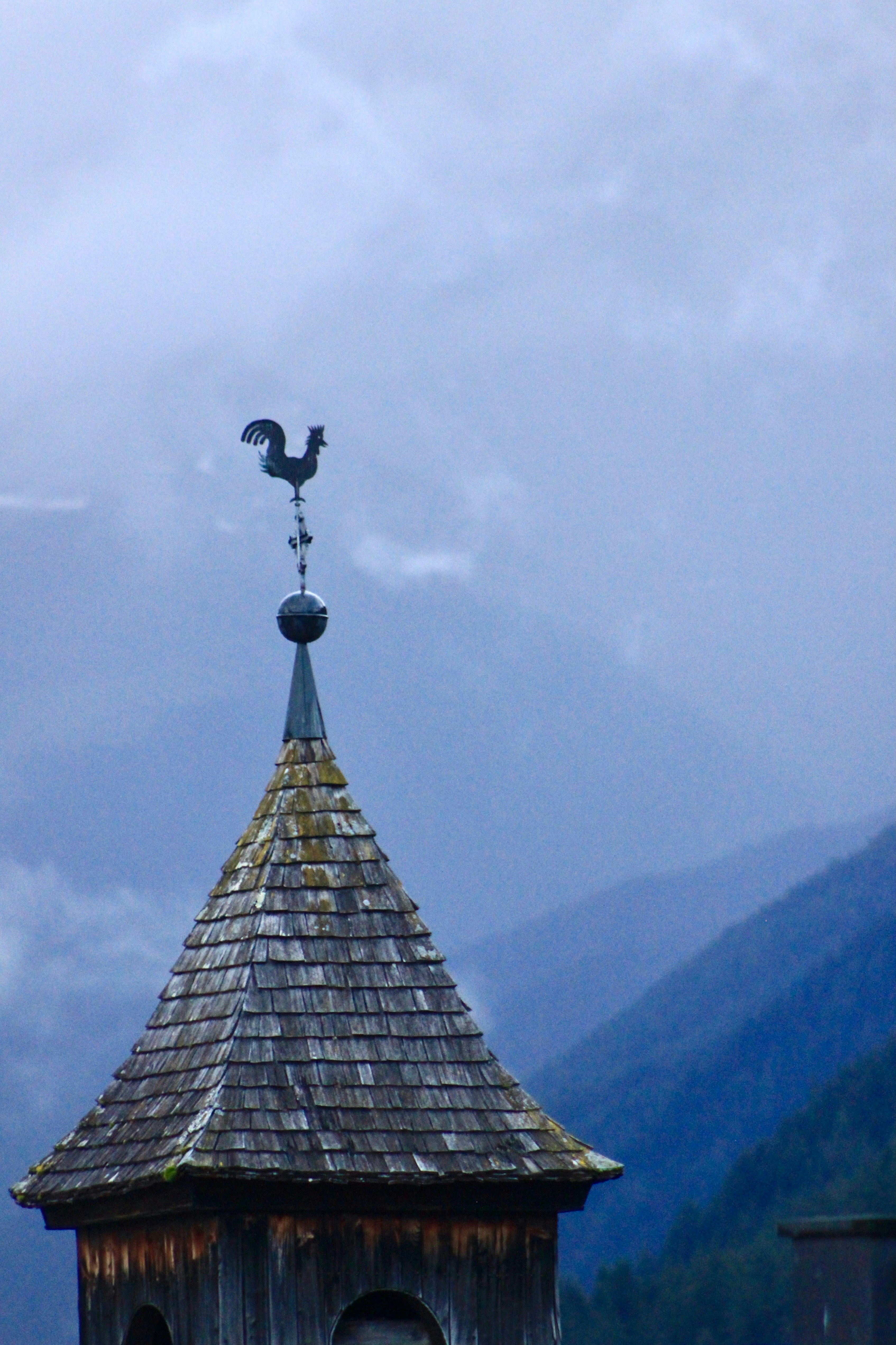 Rooster Weather Vane Soars Above a Weathered Alpine Spire