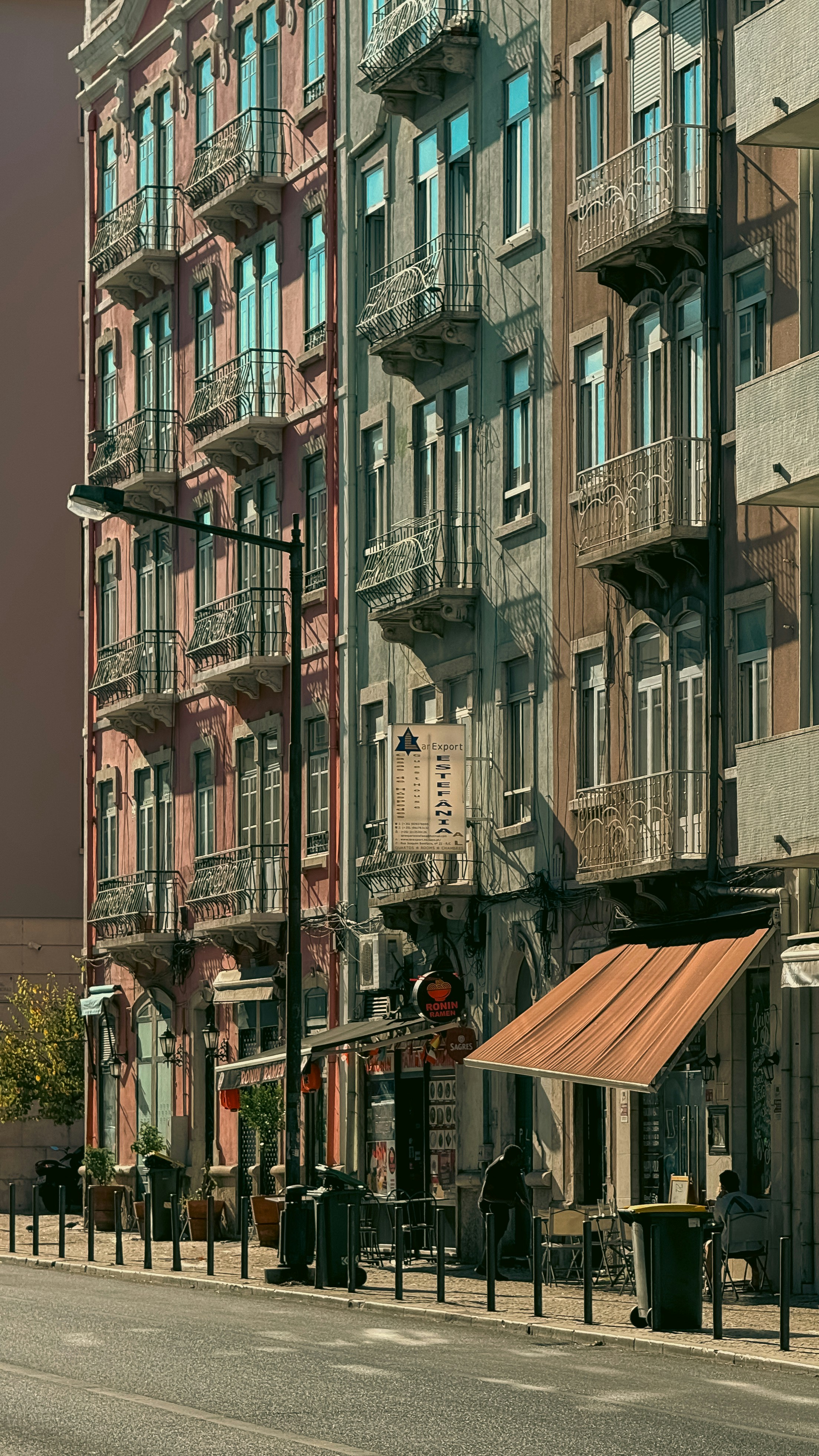 Pastel Facades and Ironwork: A Sunlit Street of Balconies