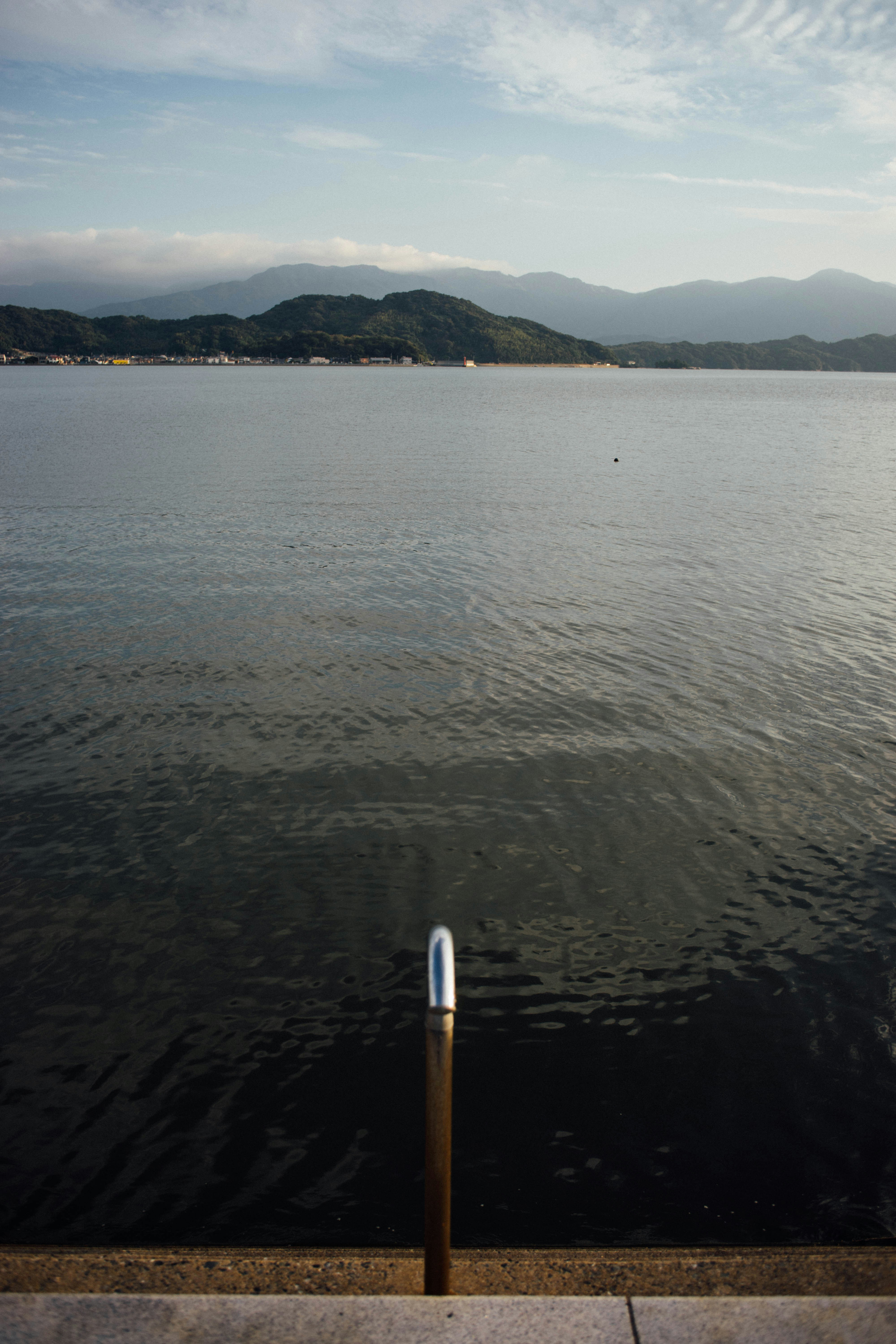 Lone Mooring Post Framing a Tranquil Lake and Distant Ridge