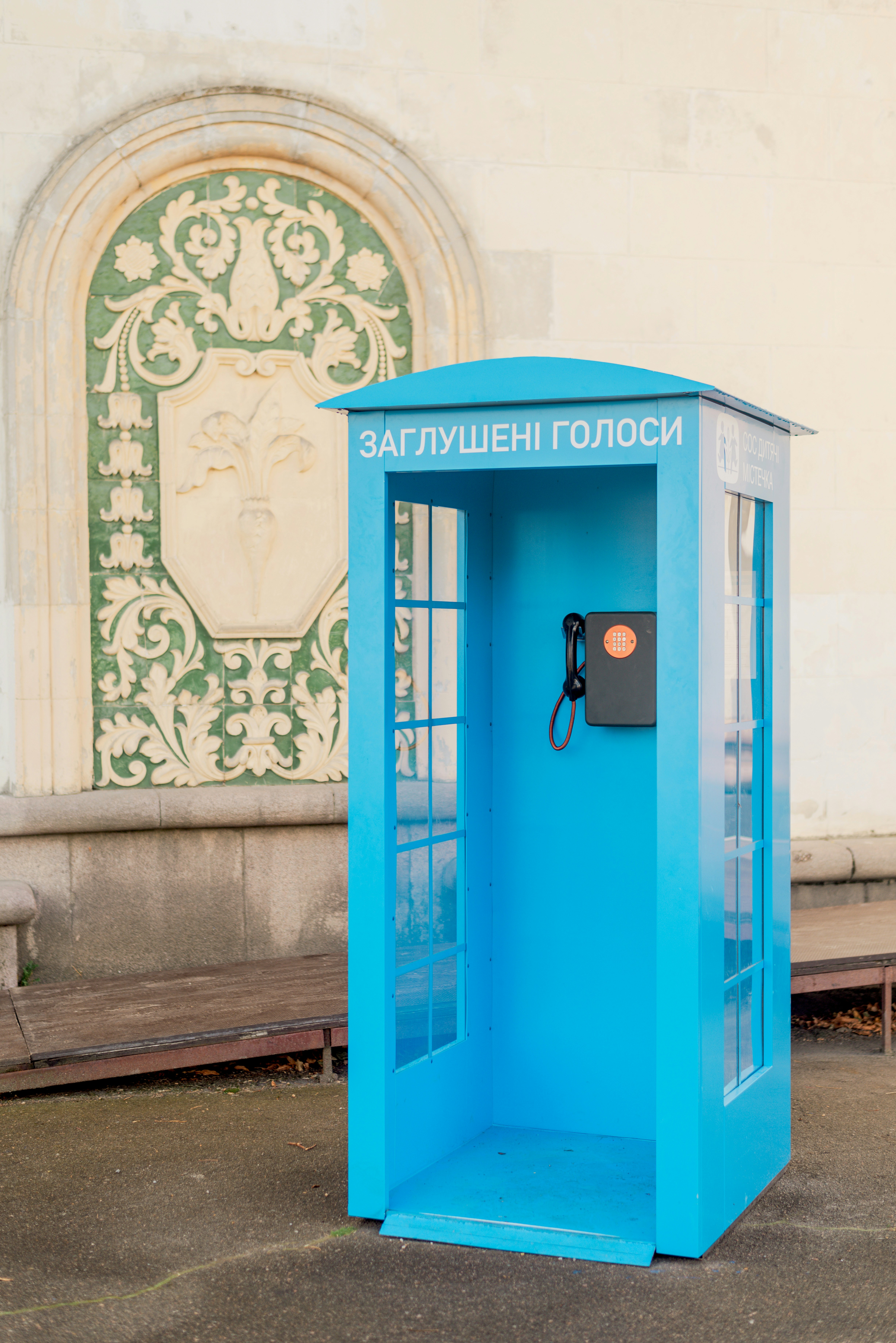 A blue phone booth sitting in front of a building photo – Free Ukraine ...