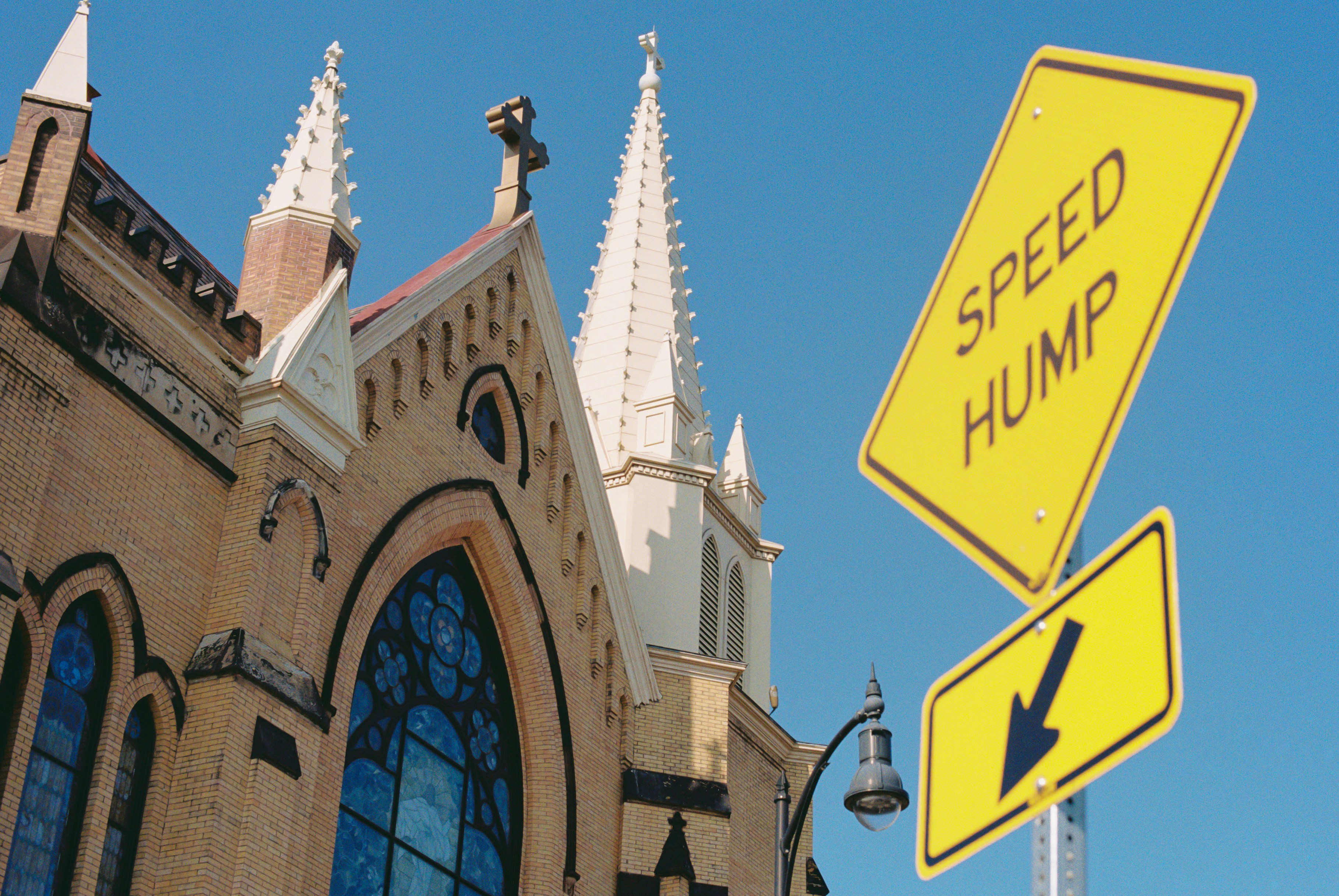 A yellow speed hump sign in front of a church photo – Free Film ...