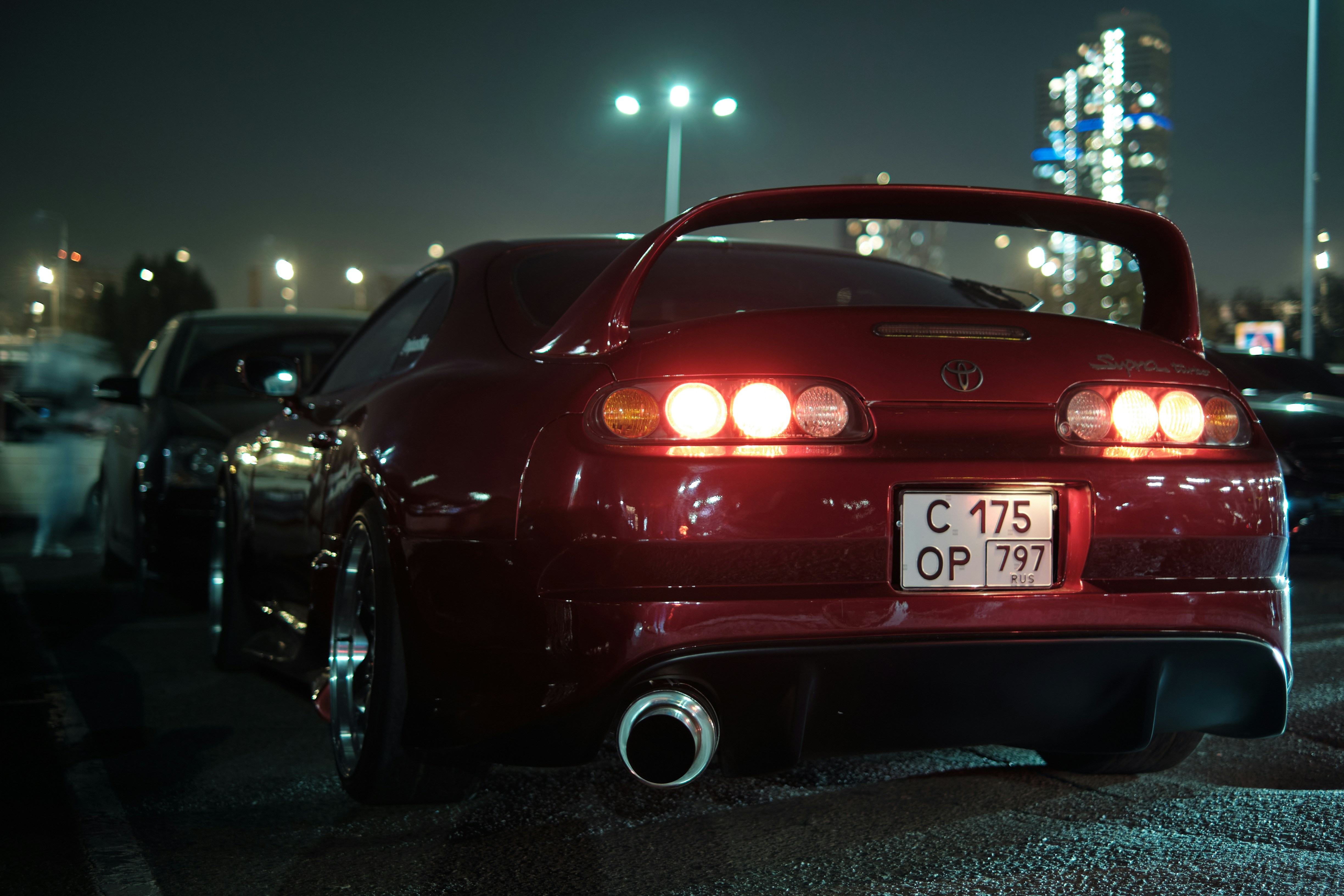 A red car parked in a parking lot at night photo – Free Toyota supra ...