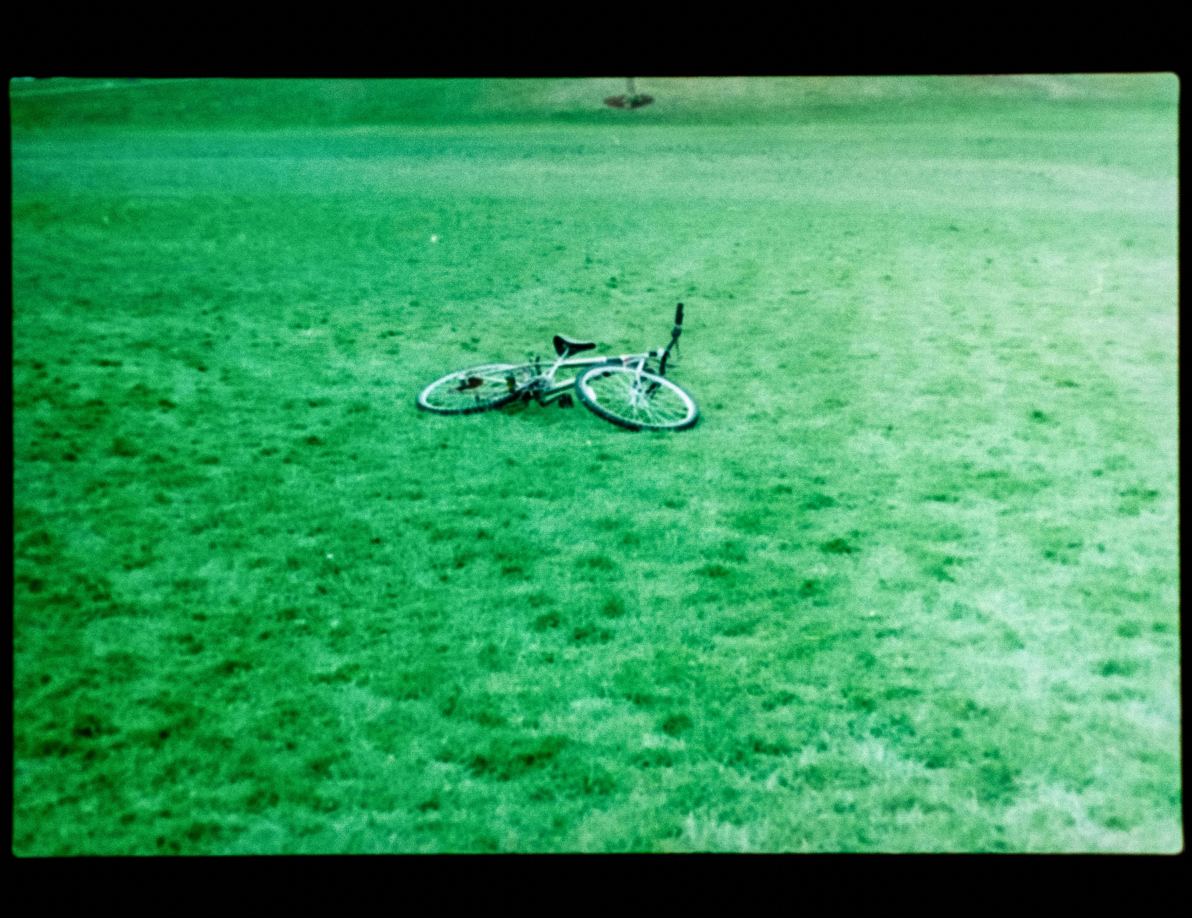 A bike laying on the ground in a field photo – Free Green Image on Unsplash