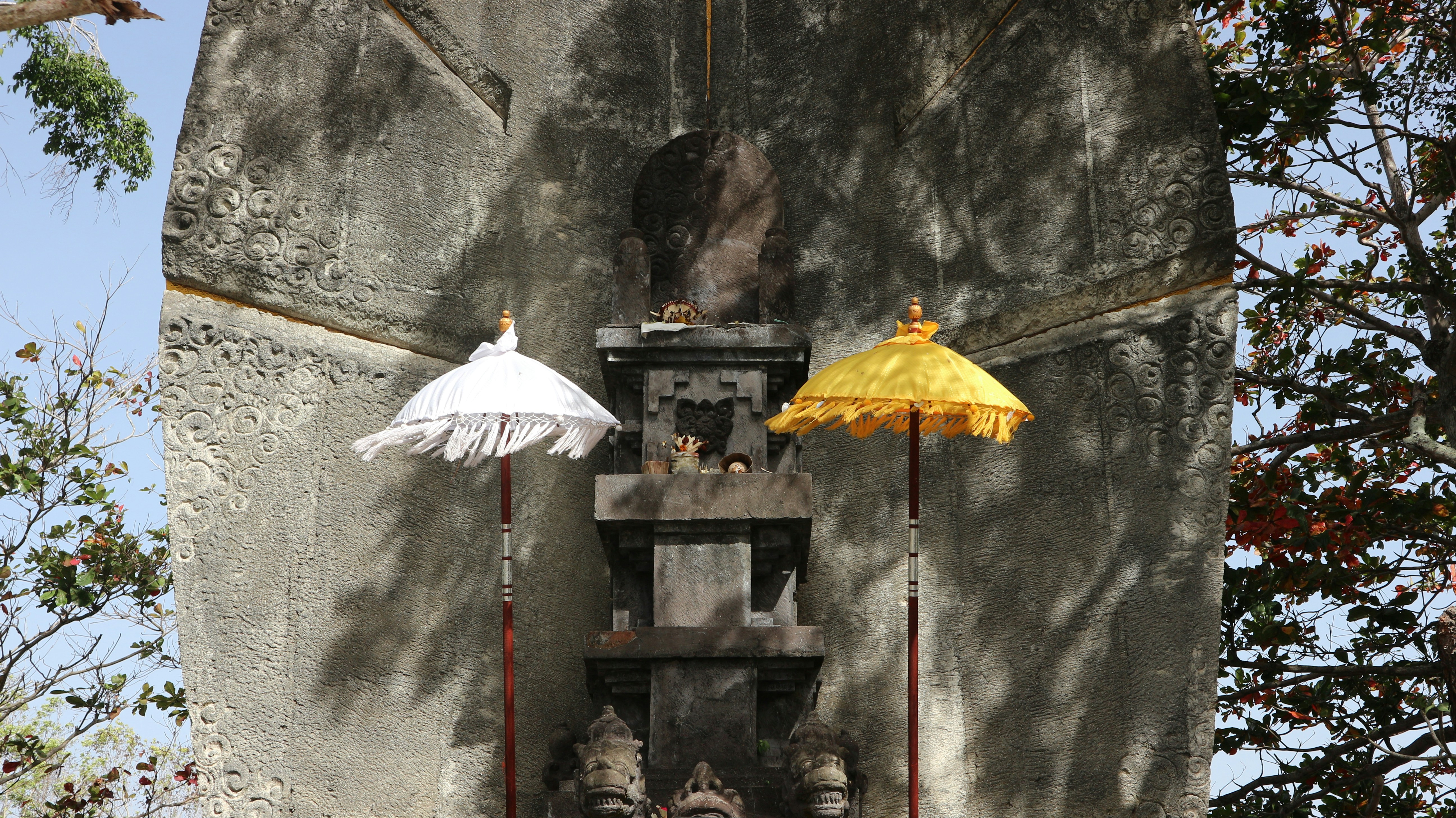 Tiered Stone Shrine Framed by Parasol Umbrellas in Dappled Light