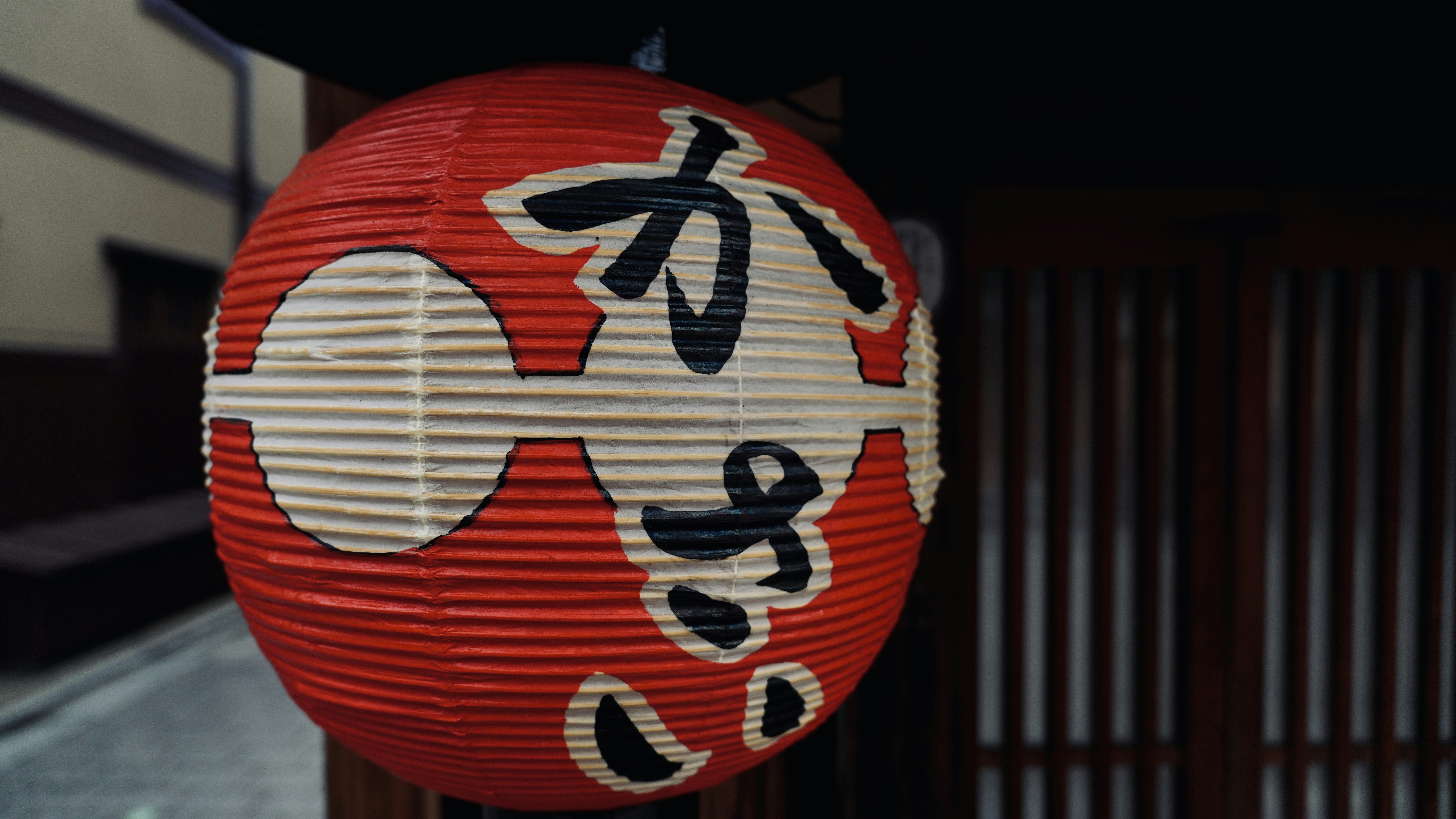 Crimson Lantern at the Gate: Quiet Glow Amid Shaded Wood