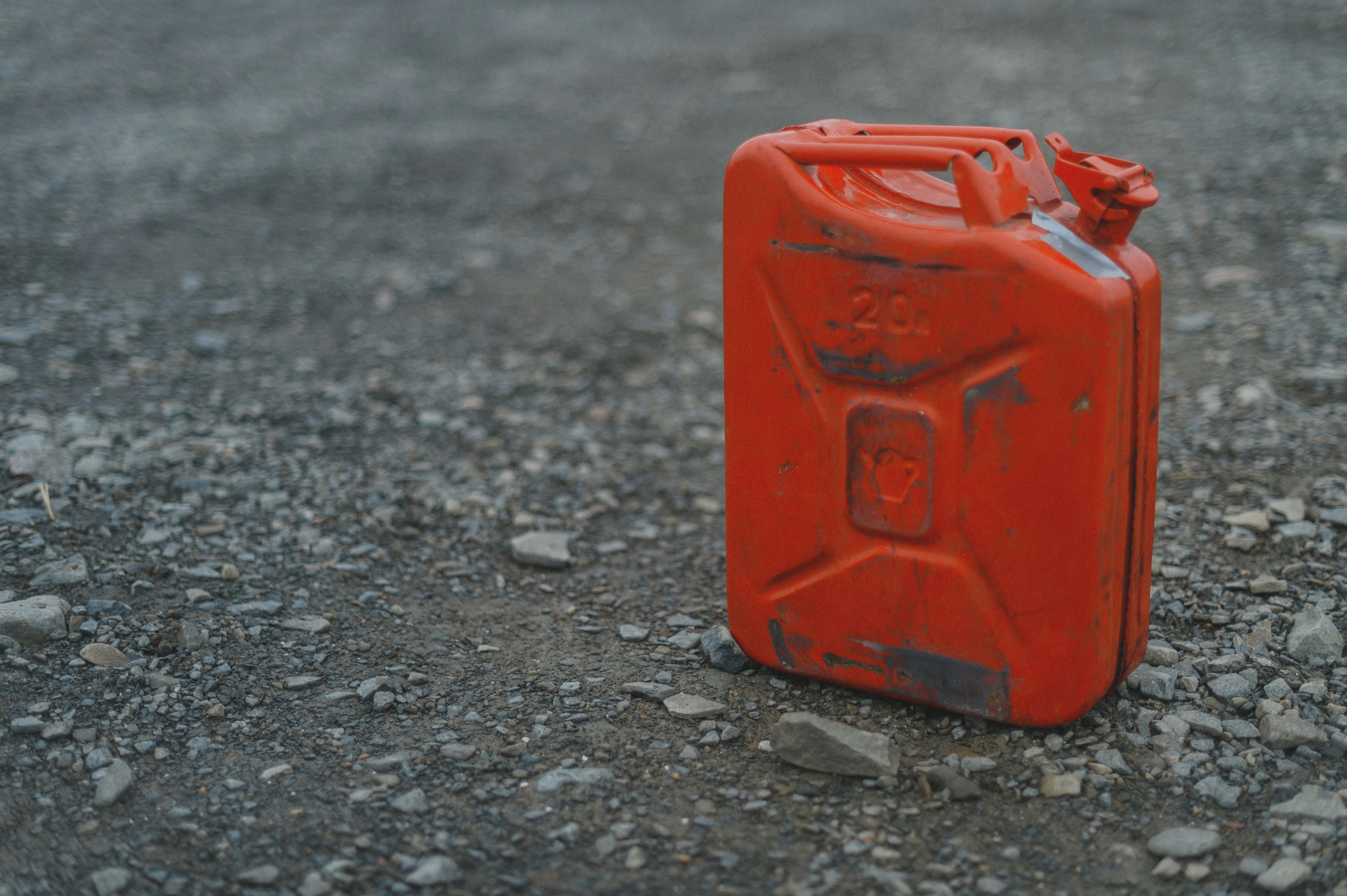 An orange gas can sitting on the ground photo – Free Russia Image on ...