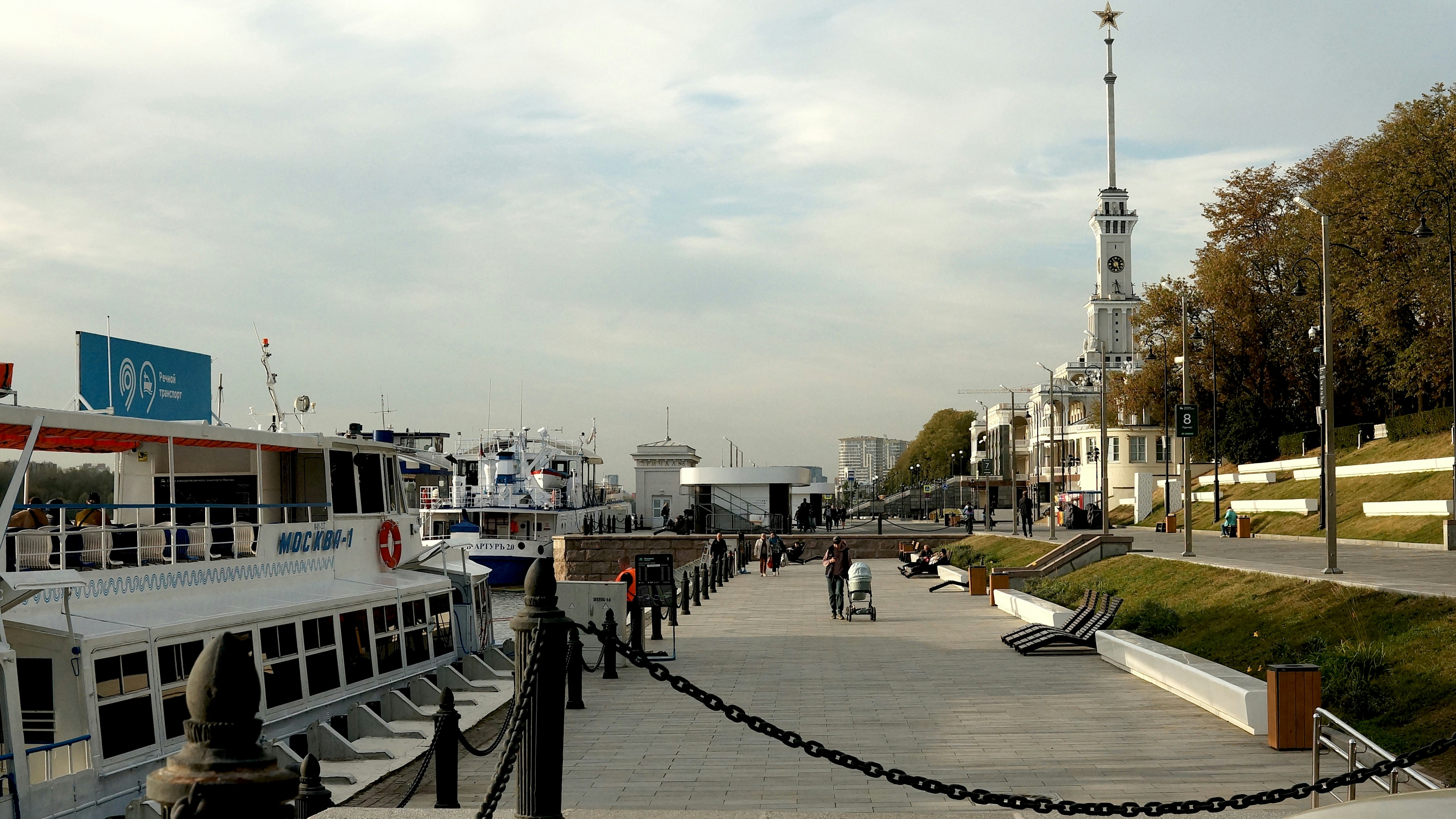 Riverside Promenade: Boats, Chains, and a Star-Topped Spire