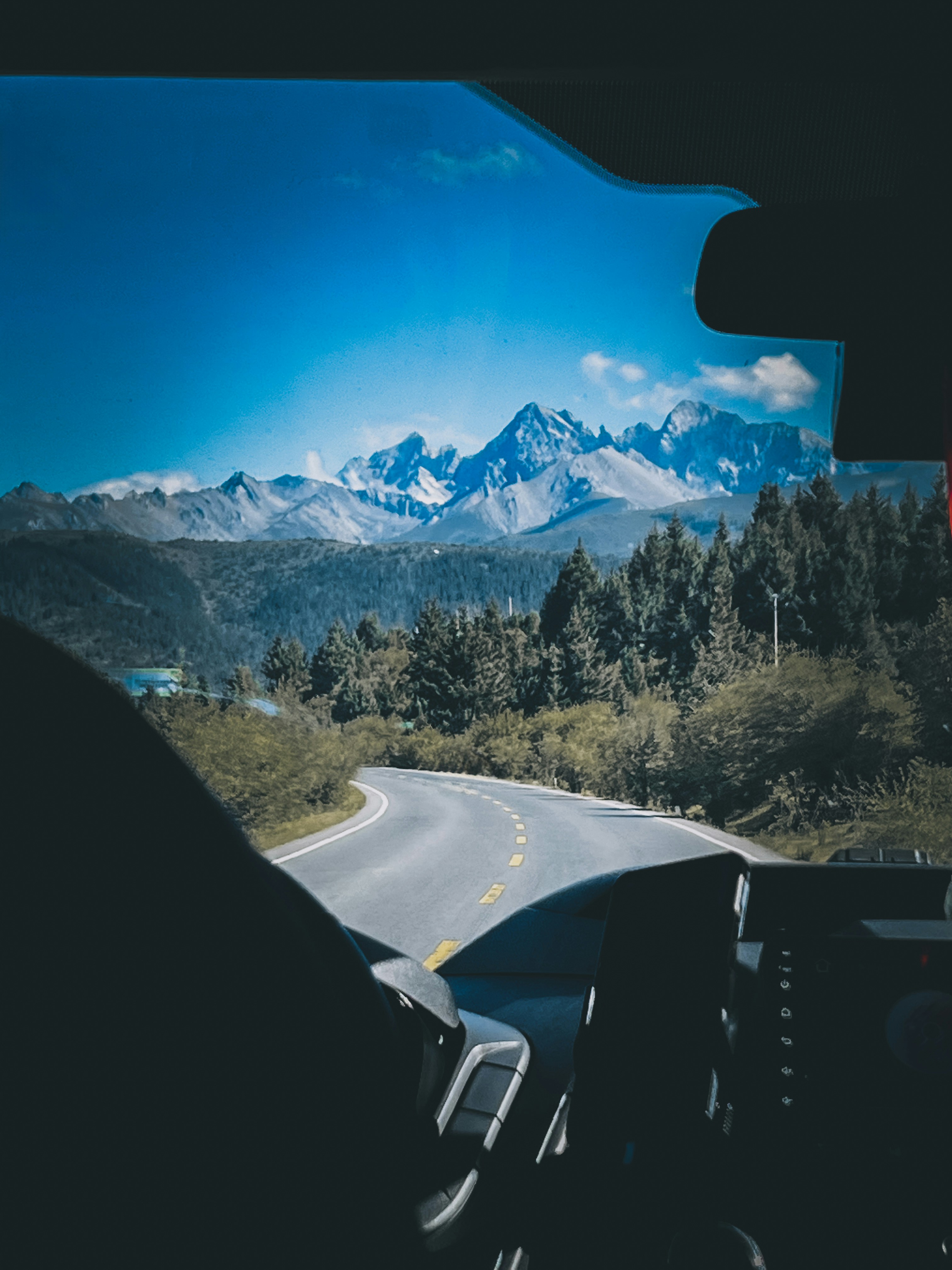 A person driving a car on a road with mountains in the background photo ...