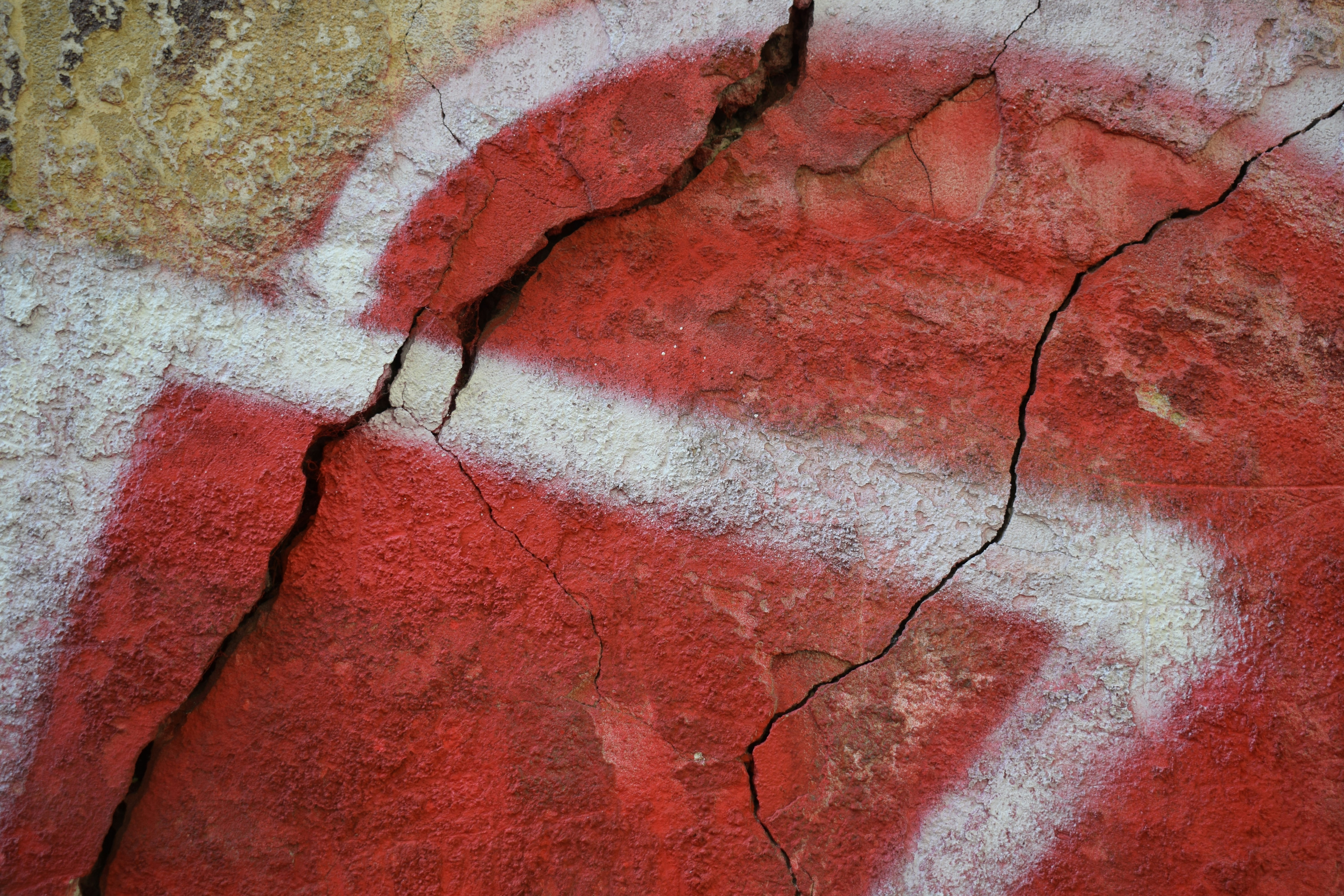 Cracked Red Wall Graffiti: Intersecting White Stripes Form Geometric Rhythm