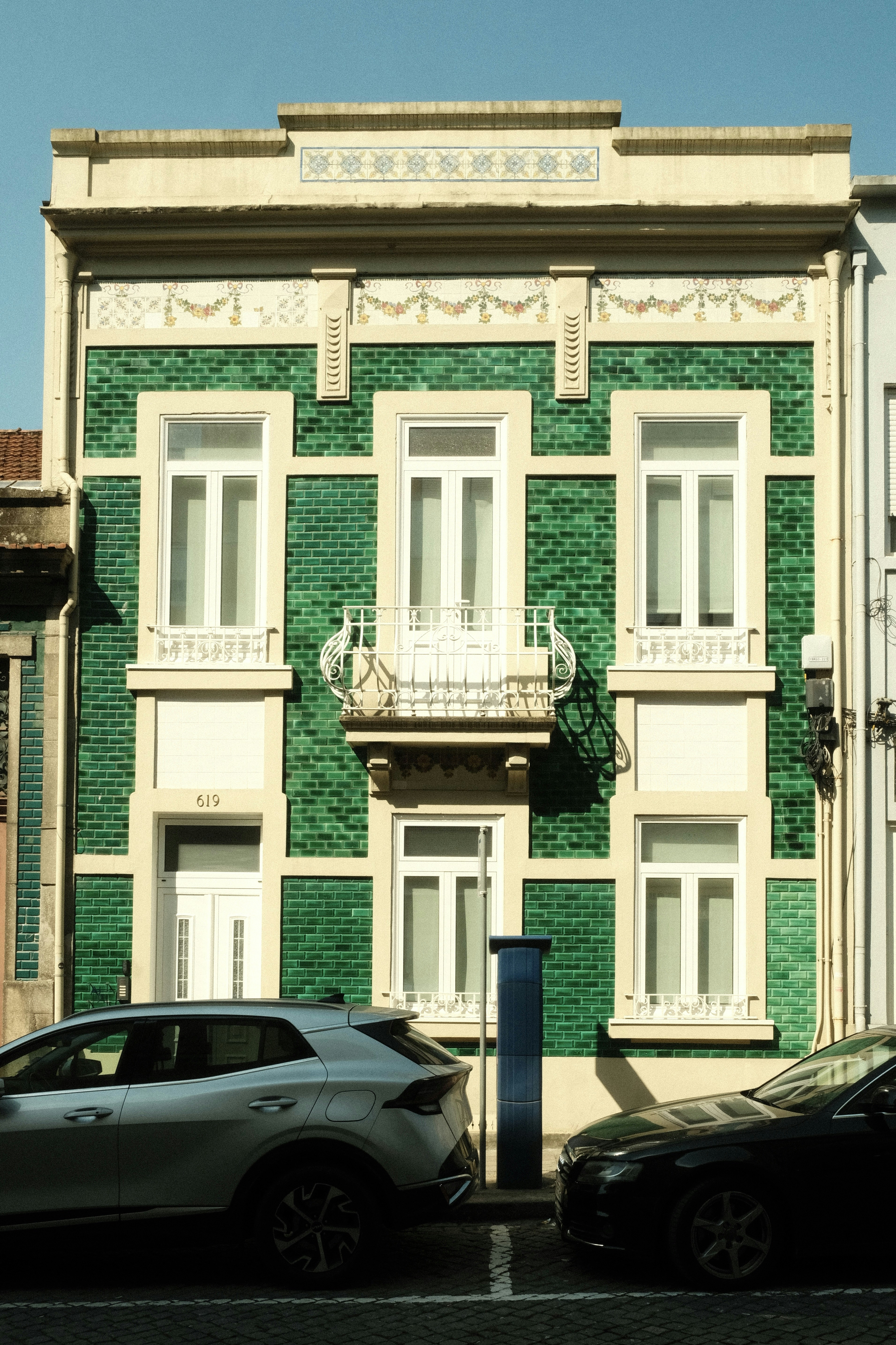 Emerald Facade at Noon: A Central Balcony Framed by White Trim