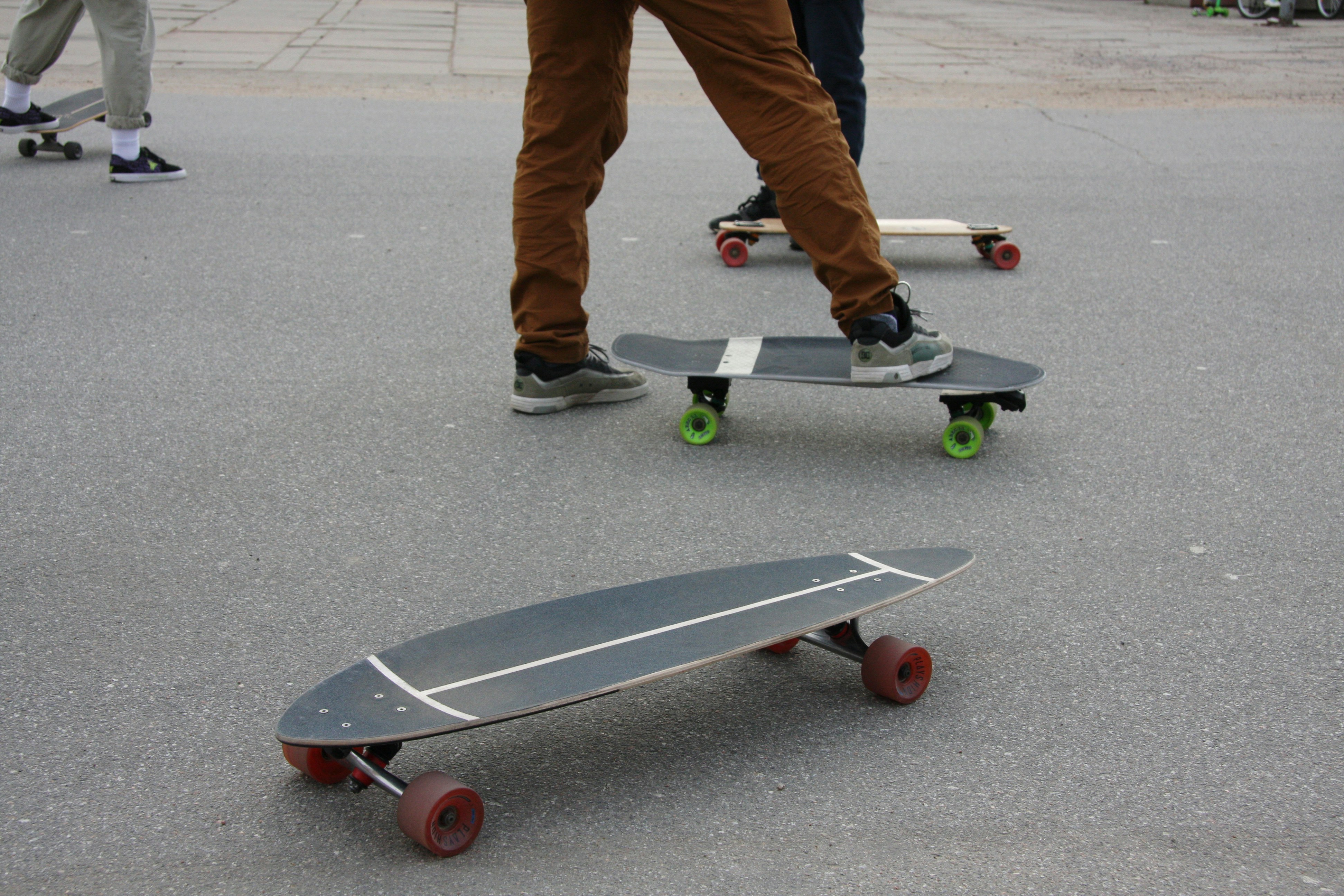 A group of people riding skateboards down a street photo – Free Human ...