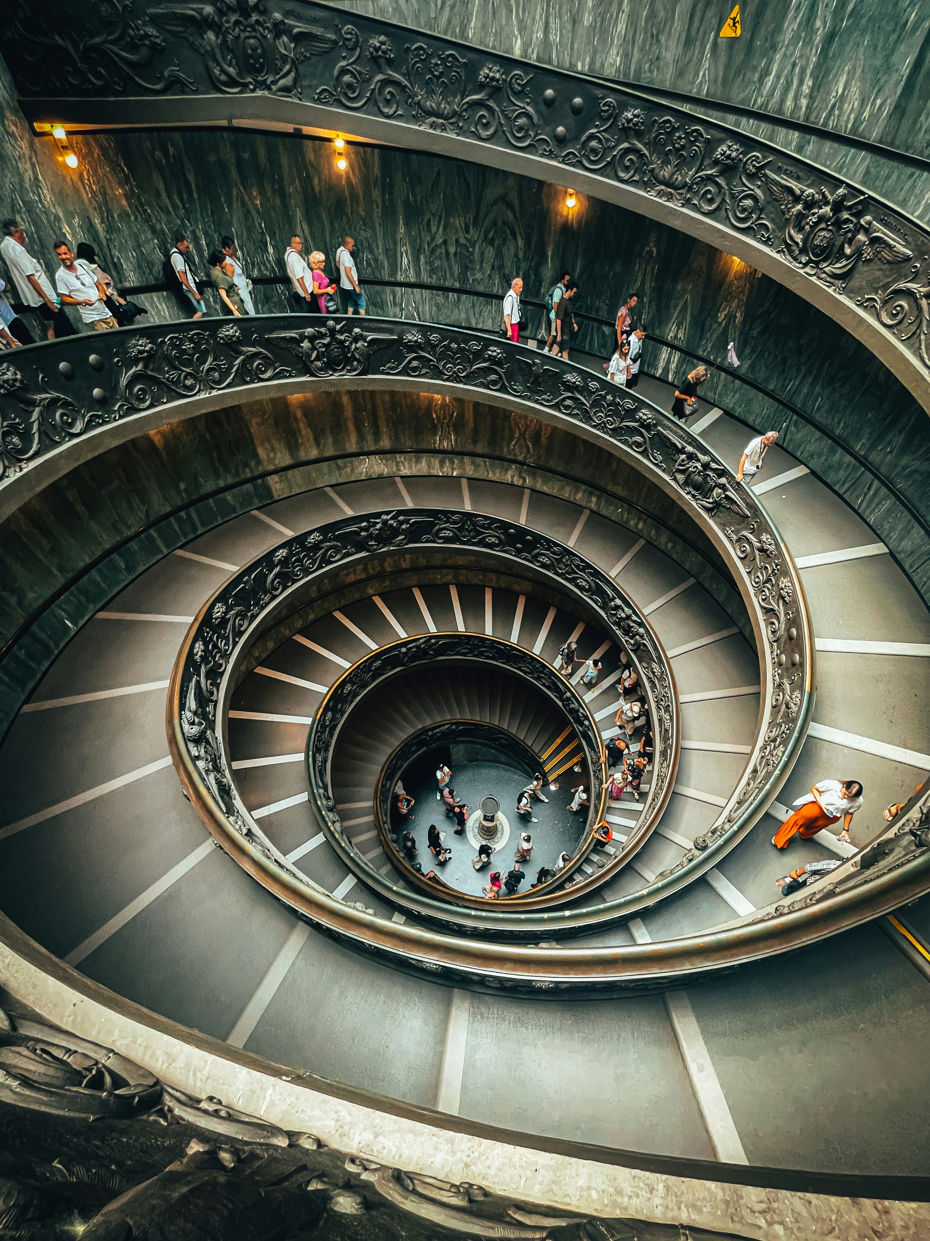 Spiral Descent: A Crown of Tourists Winding Through an Ornate Atrium