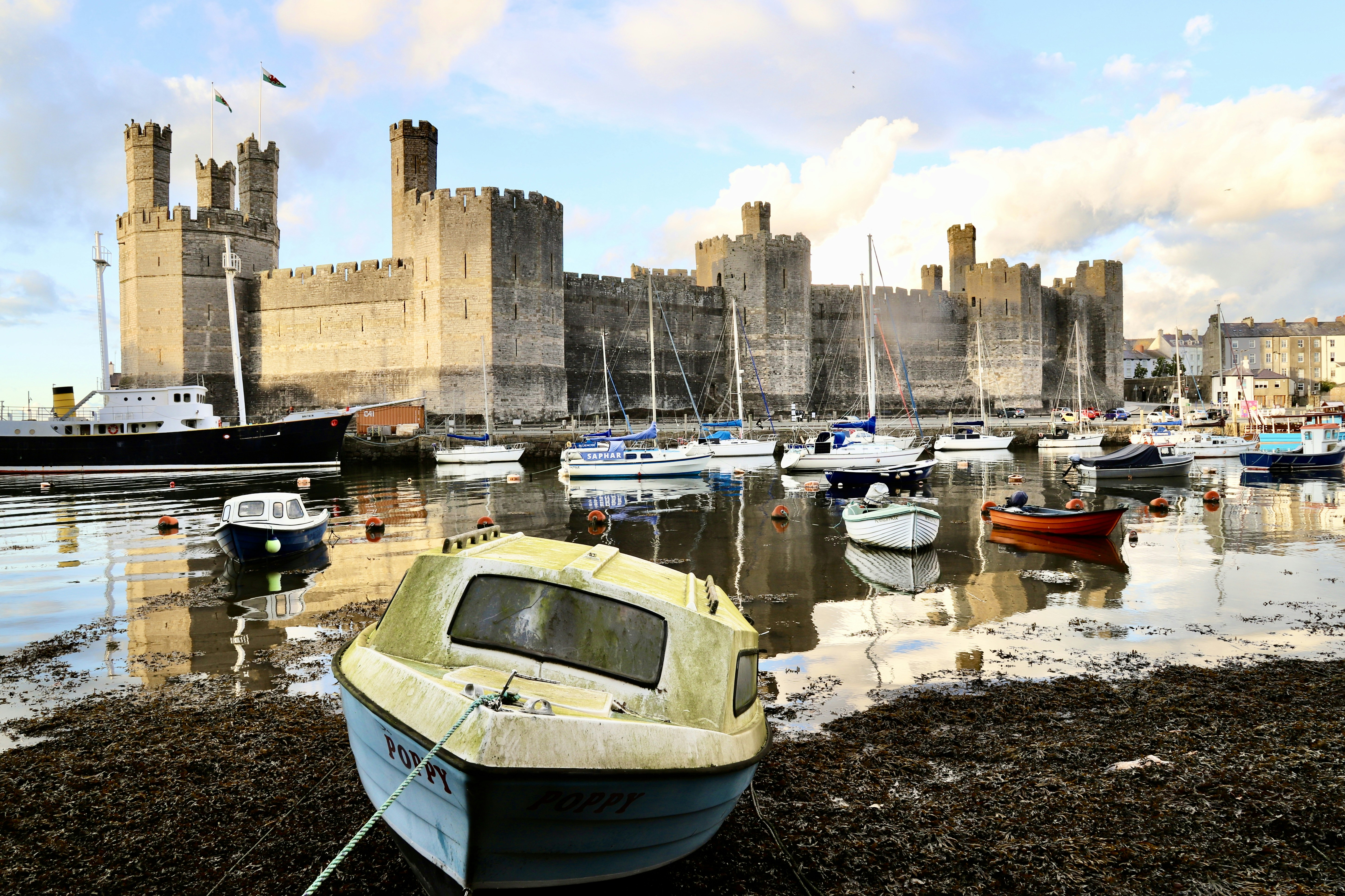 A row of boats sitting on top of a beach photo – Free Caernarfon castle ...