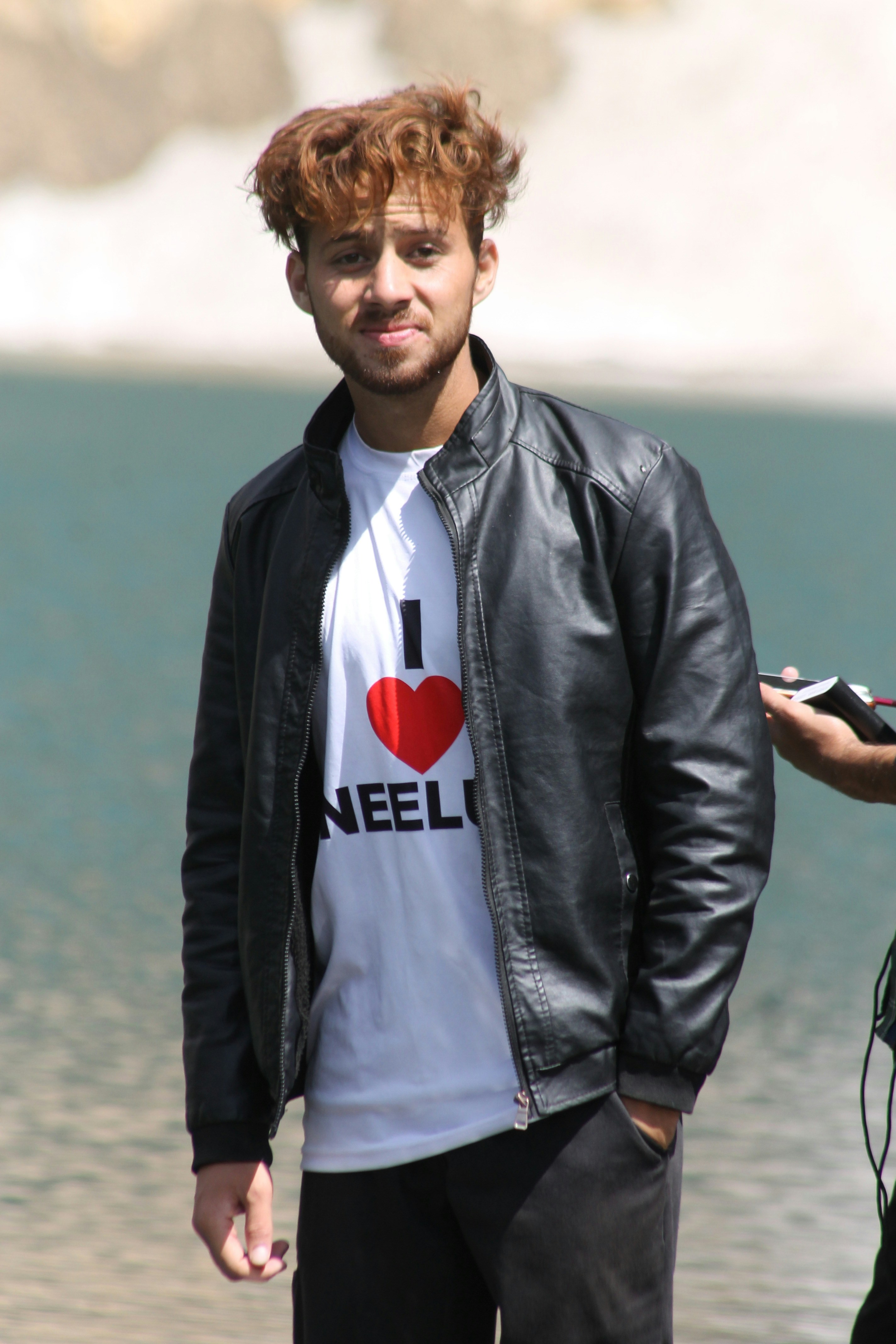 A man in a leather jacket standing next to a lake photo – Free Black ...