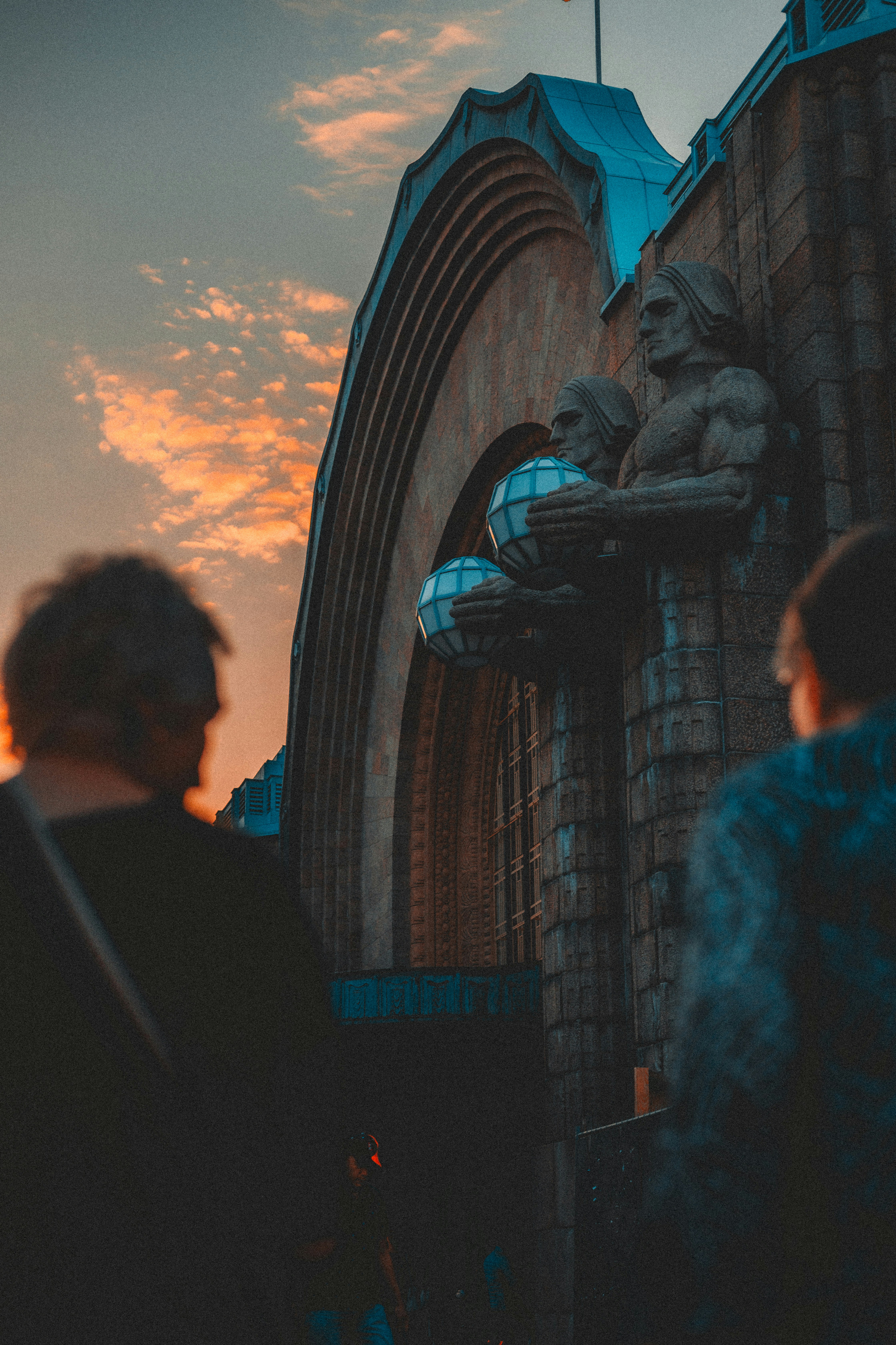 Lantern-Bearing Giants at the Arch: Sunset Light on Stone Guardians