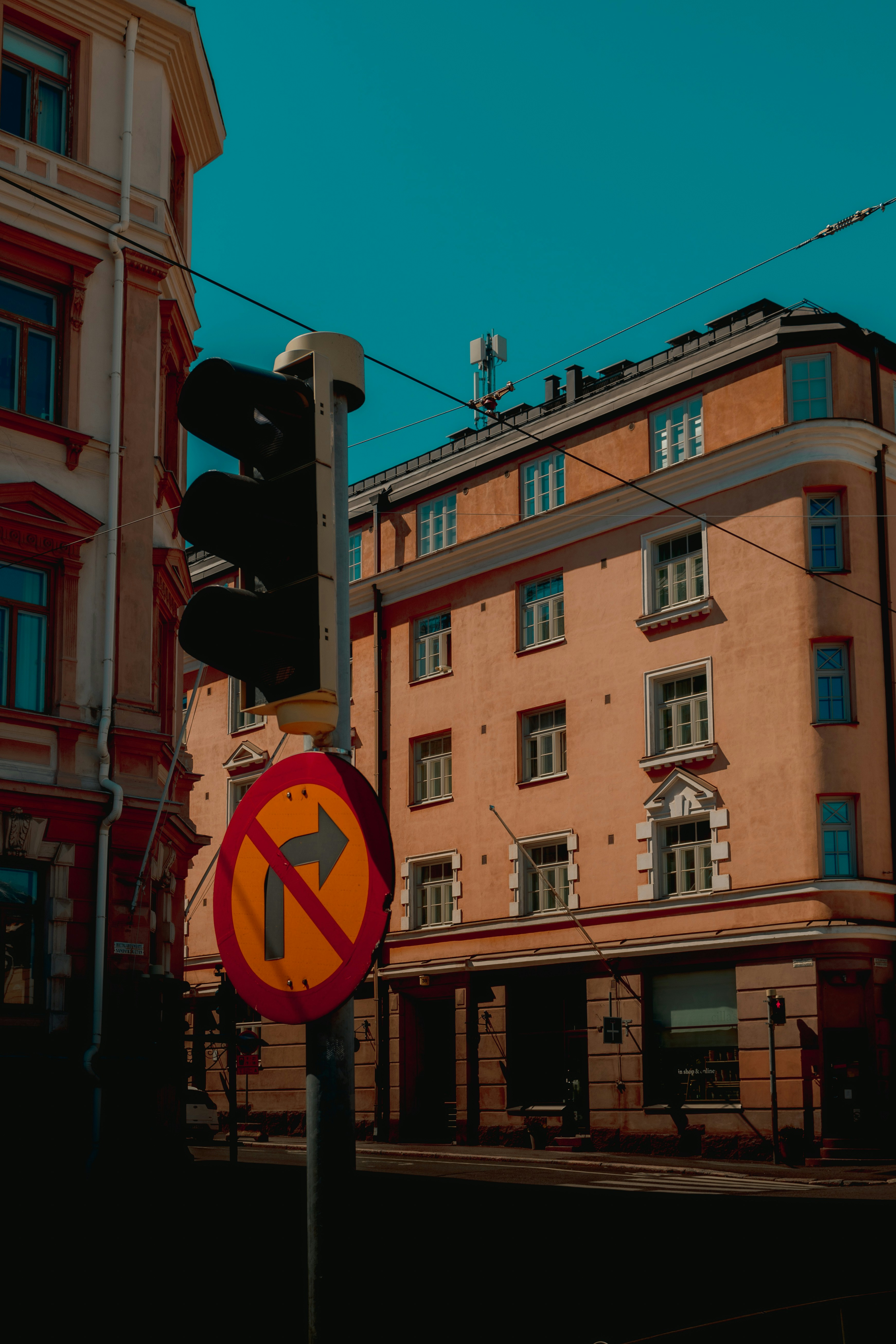 Teal Sky, Timeworn Facades: A Street Corner Framed by a Prominent Traffic Sign
