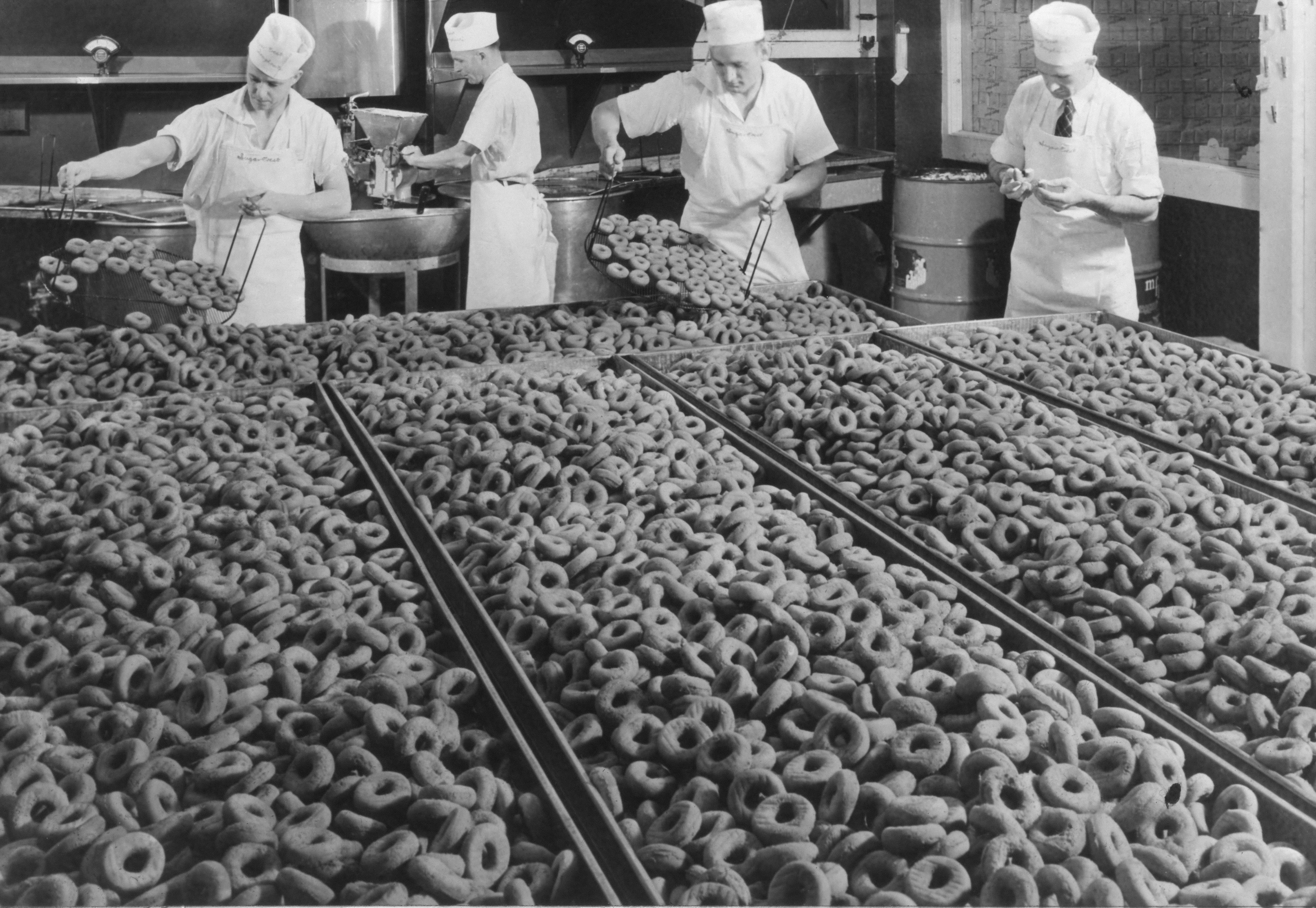 A black and white photo of workers in a doughnut factory photo – Free ...