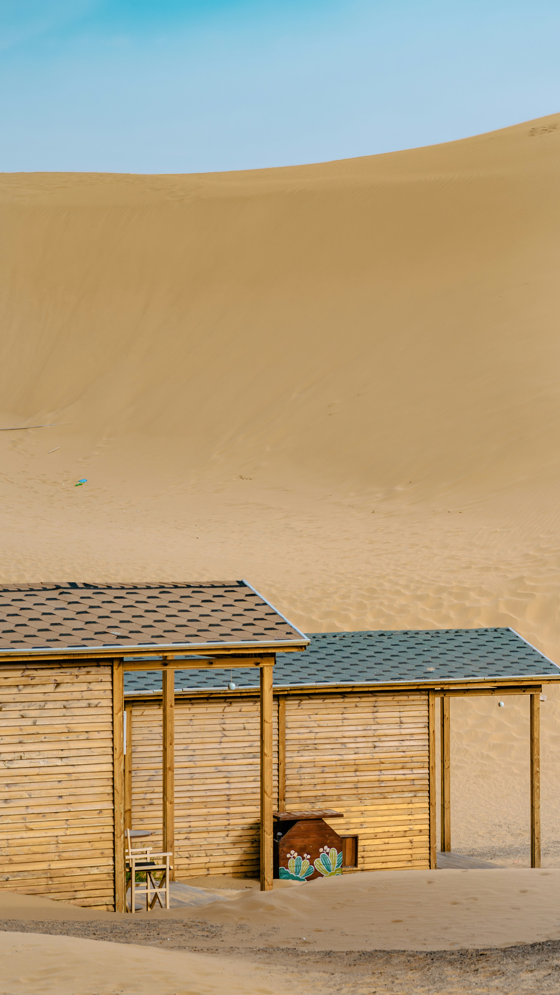 Sandy Dunes Meet Wooden Cabins: A Quiet Beach of the Desert
