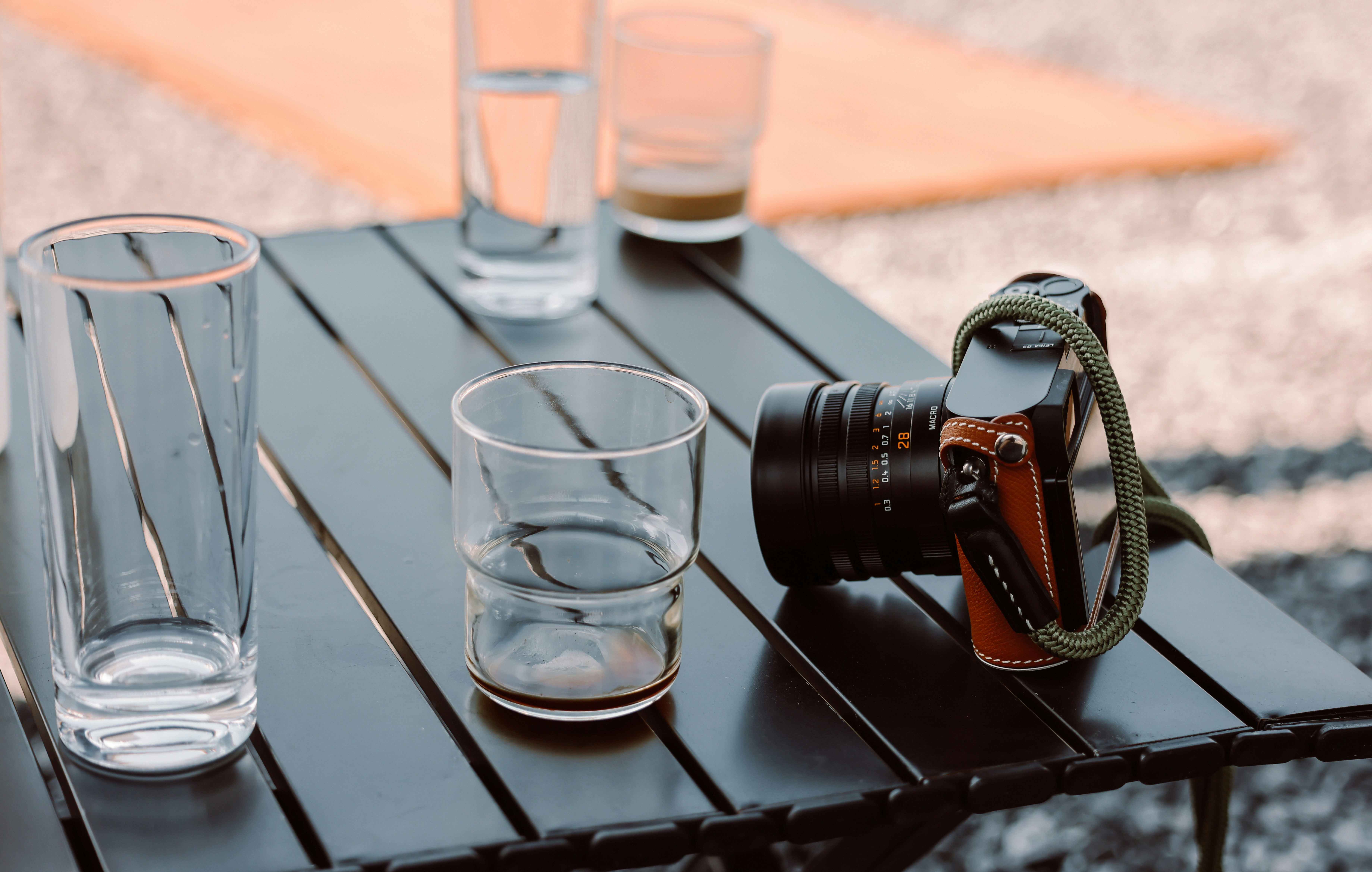 Patio Still Life: A Canon Camera and Glassware on a Dark Slatted Table