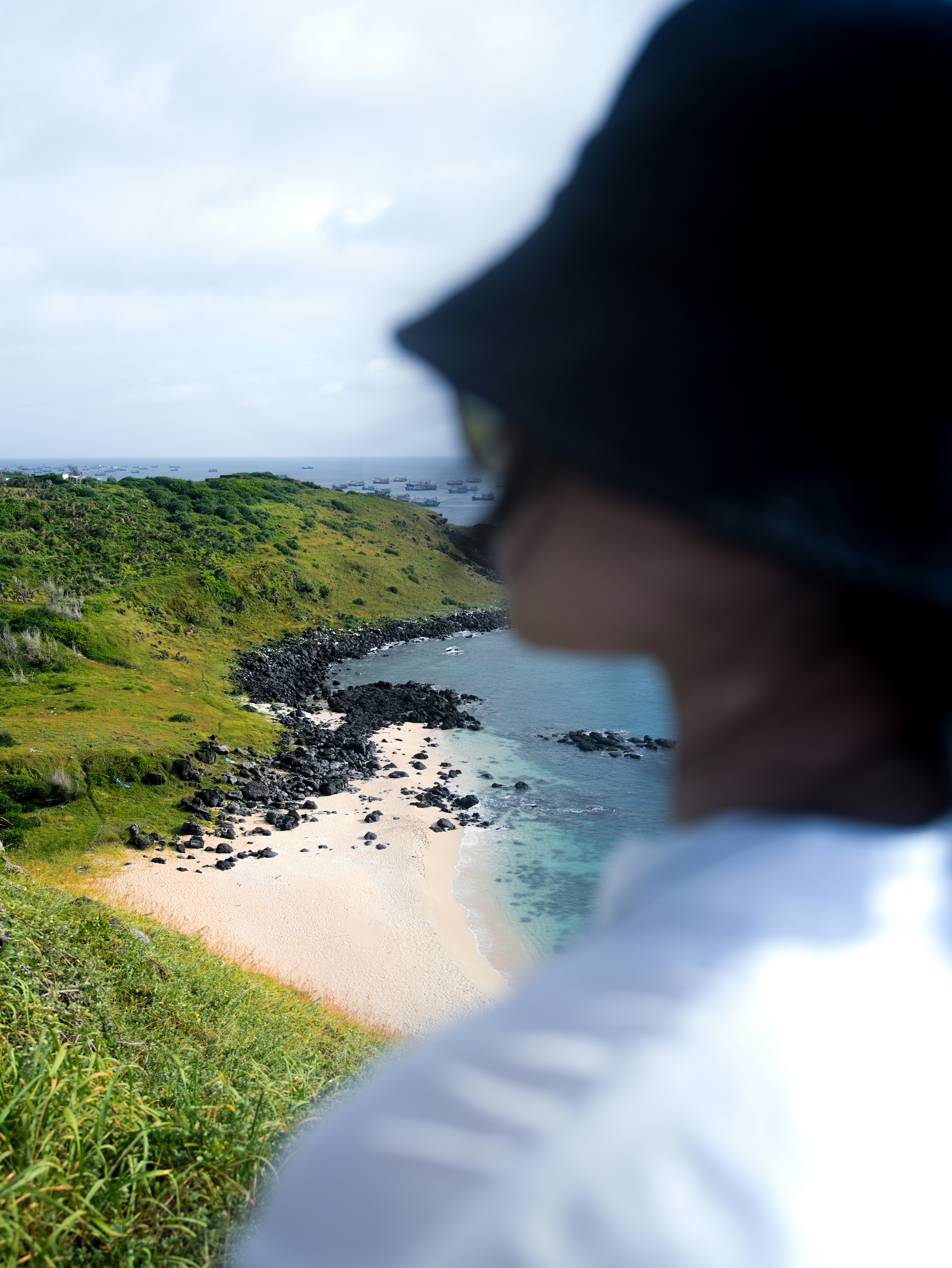 A man standing on top of a lush green hillside