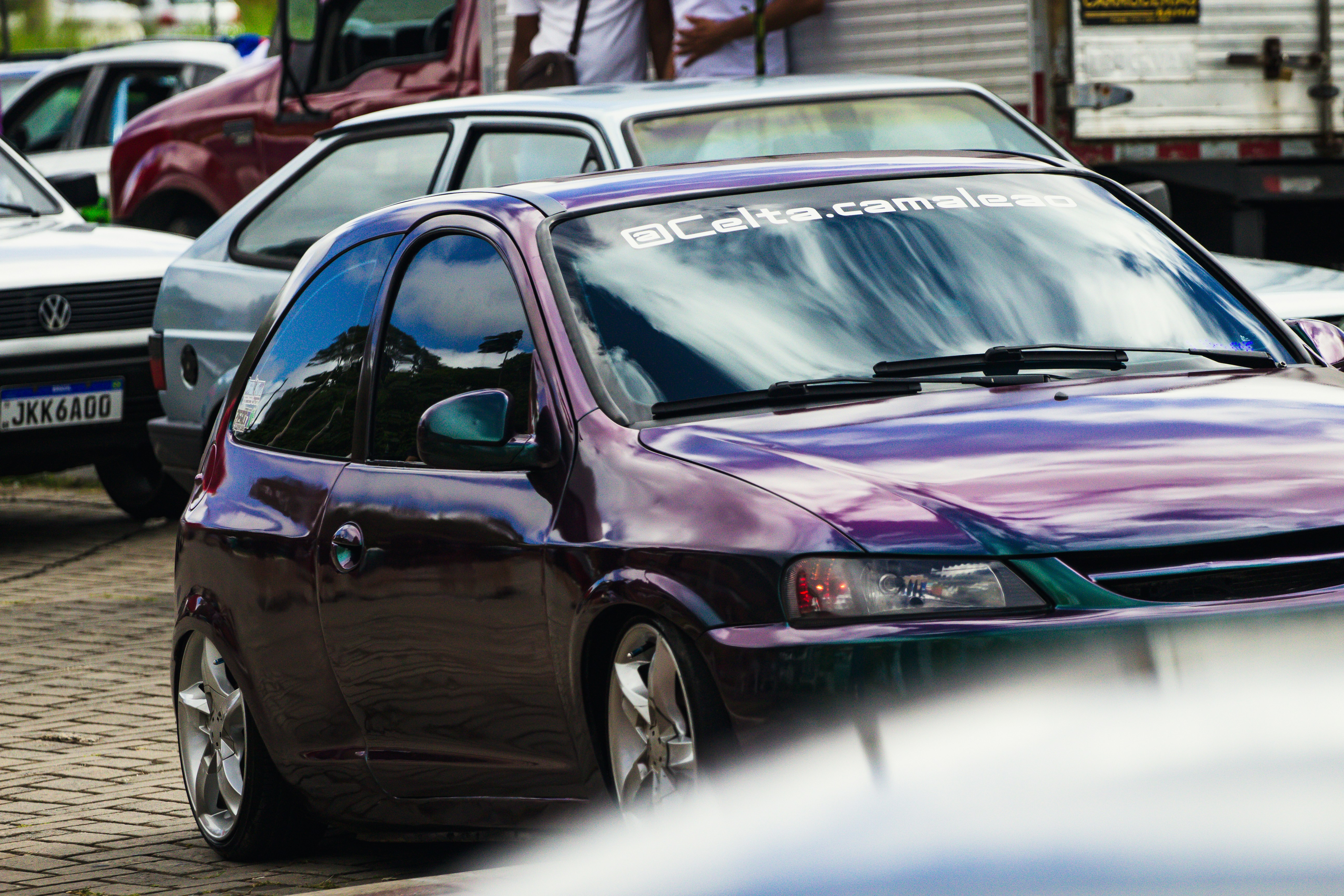 Purple coupe in a parking lot: reflections and motion blur in a casual street scene