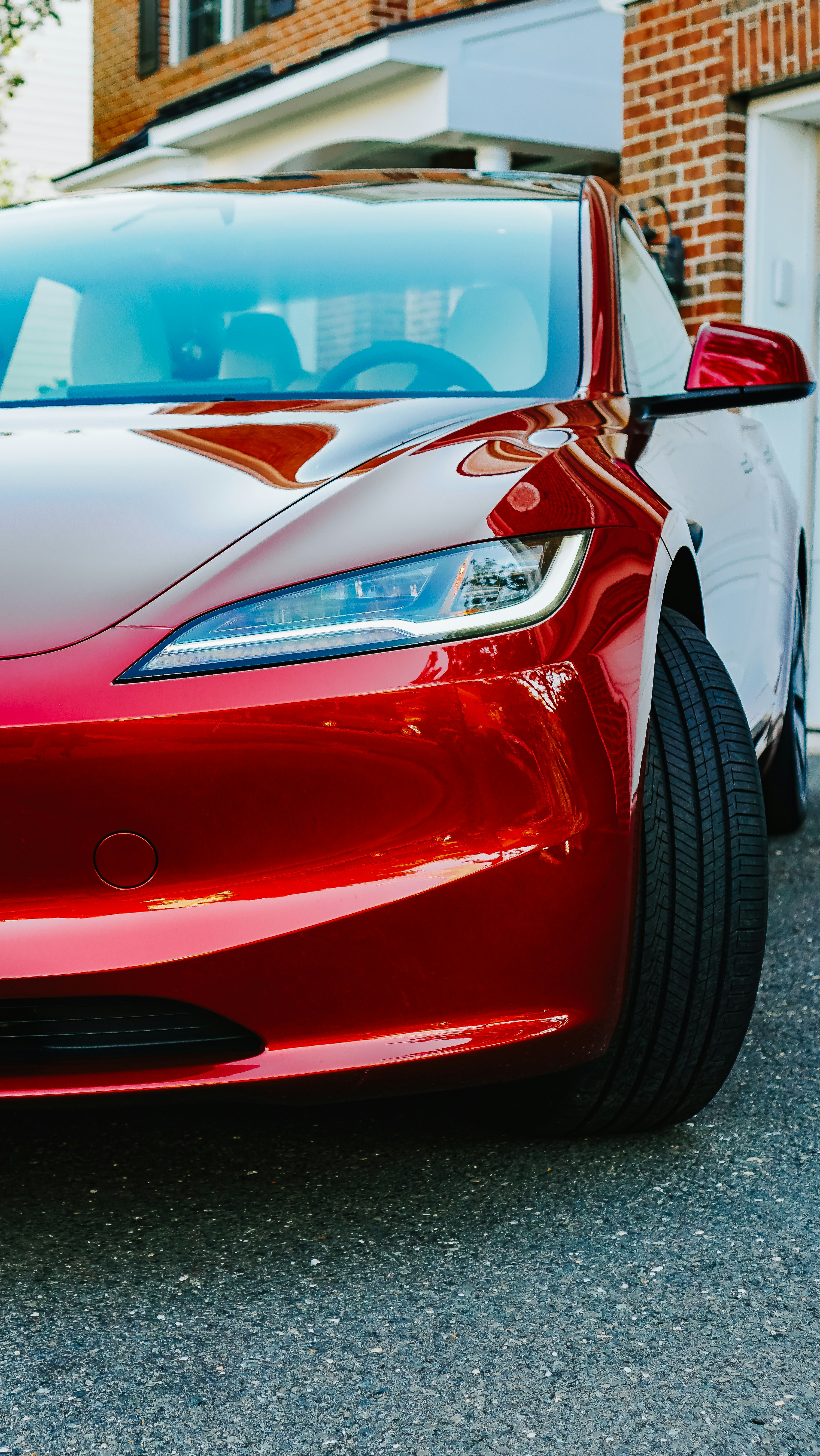 A red car parked in front of a brick building photo – Free Phone ...
