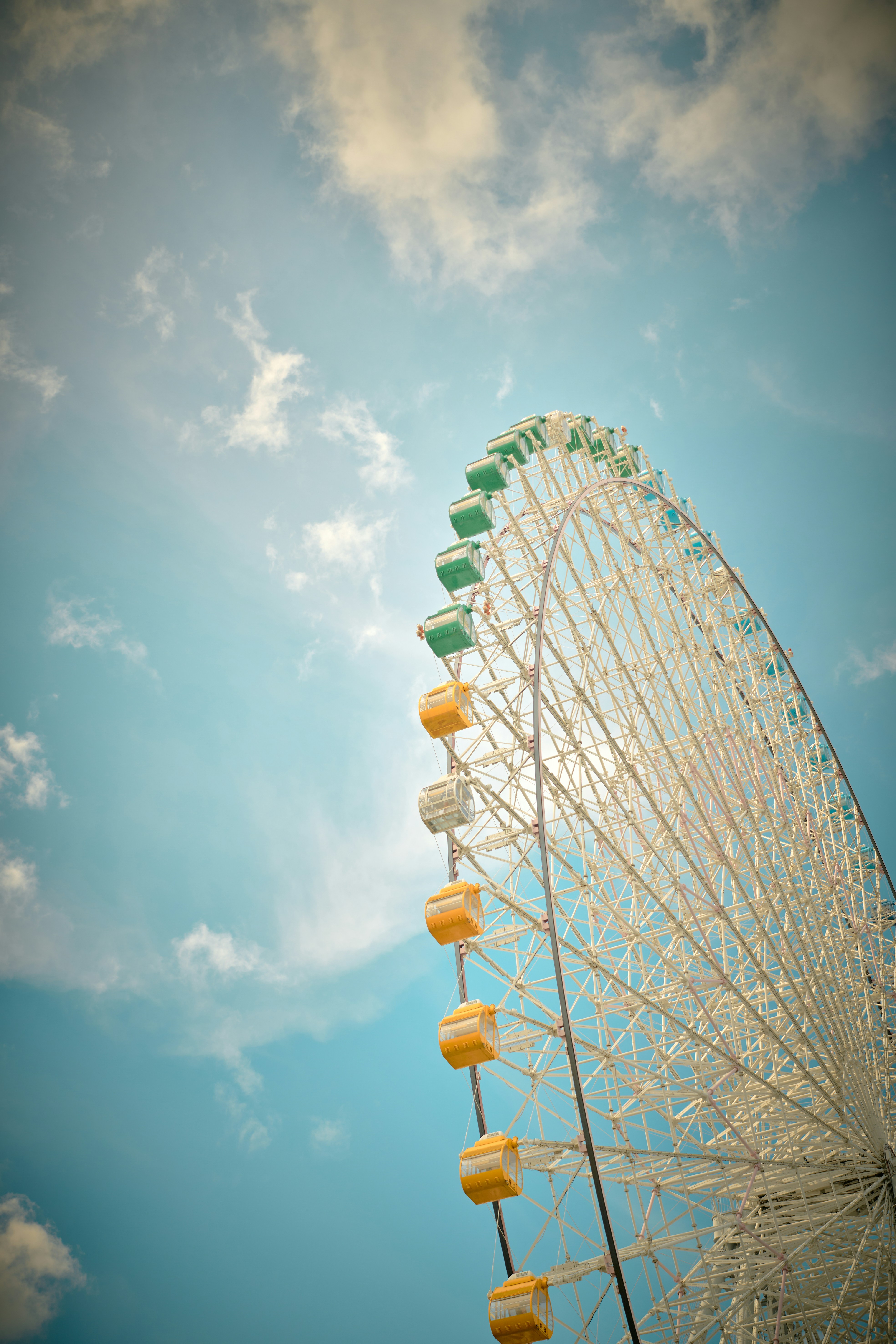 Emerald Wheel: A Ferris Arc Rises Against a Cerulean Sky