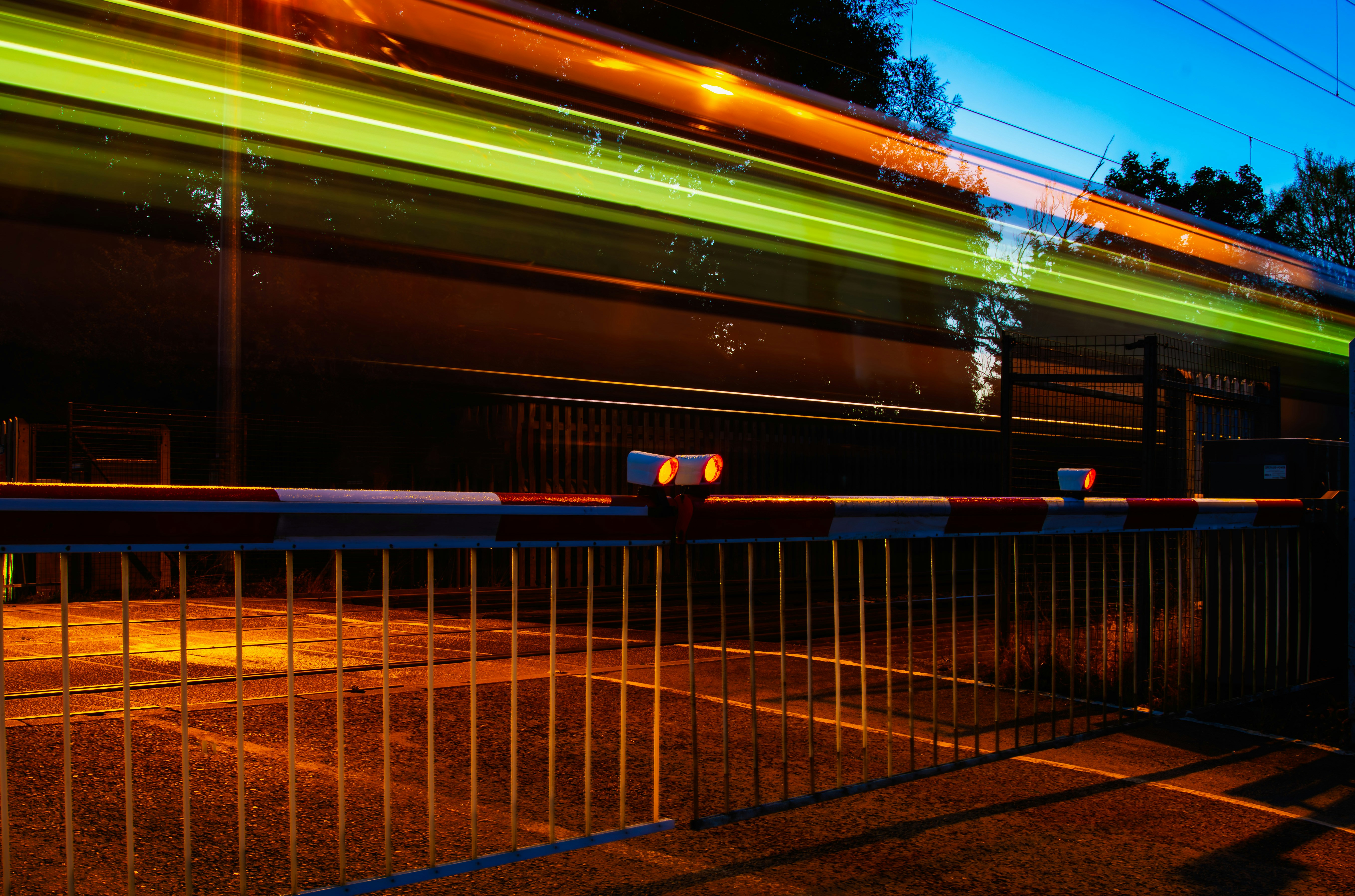 A train passing by a fence at night photo – Free Train Image on Unsplash