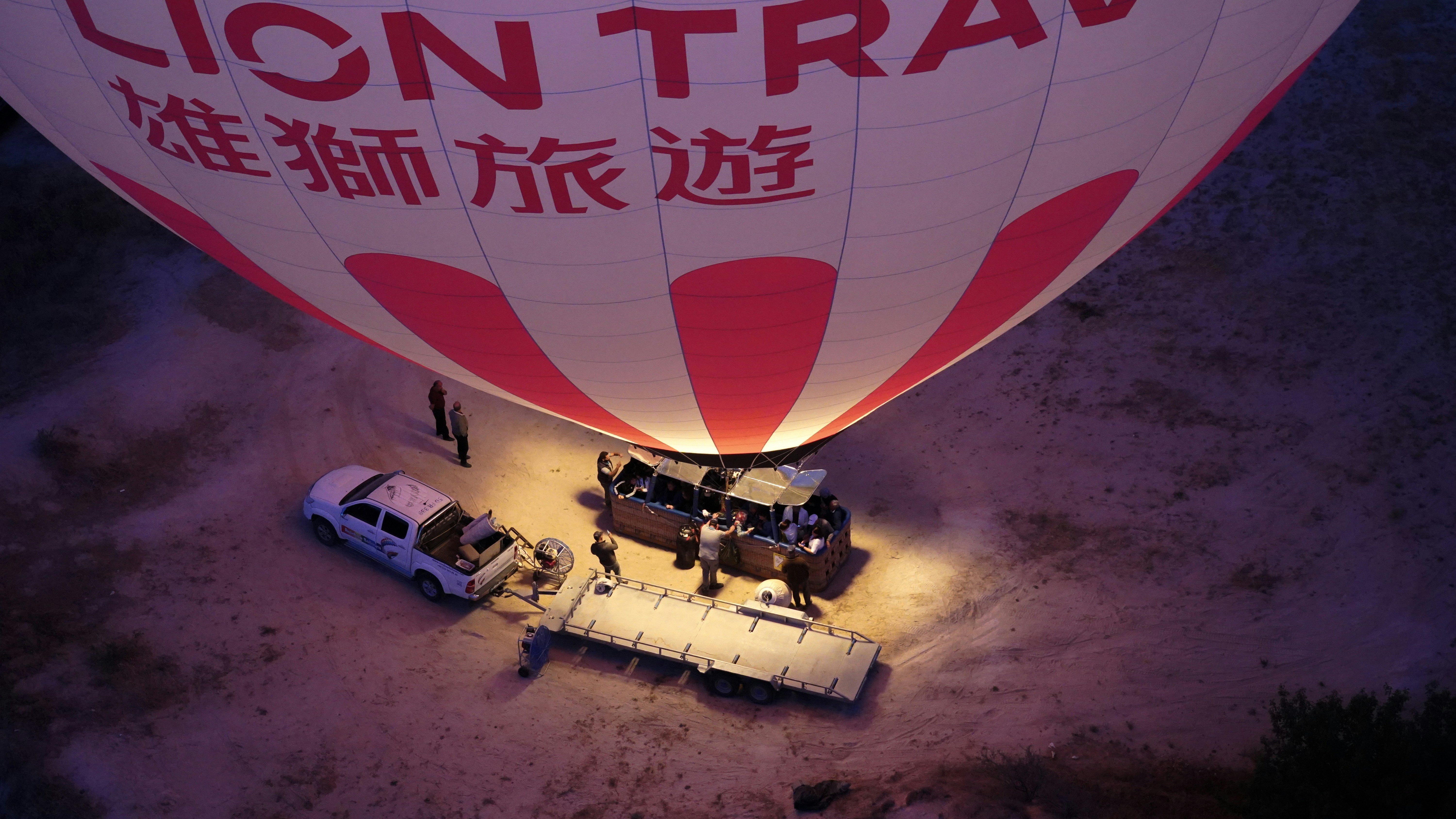 People boarding a hot air balloon with a pickup truck and trailer early morning in Cappadocia Turkey balloon festival