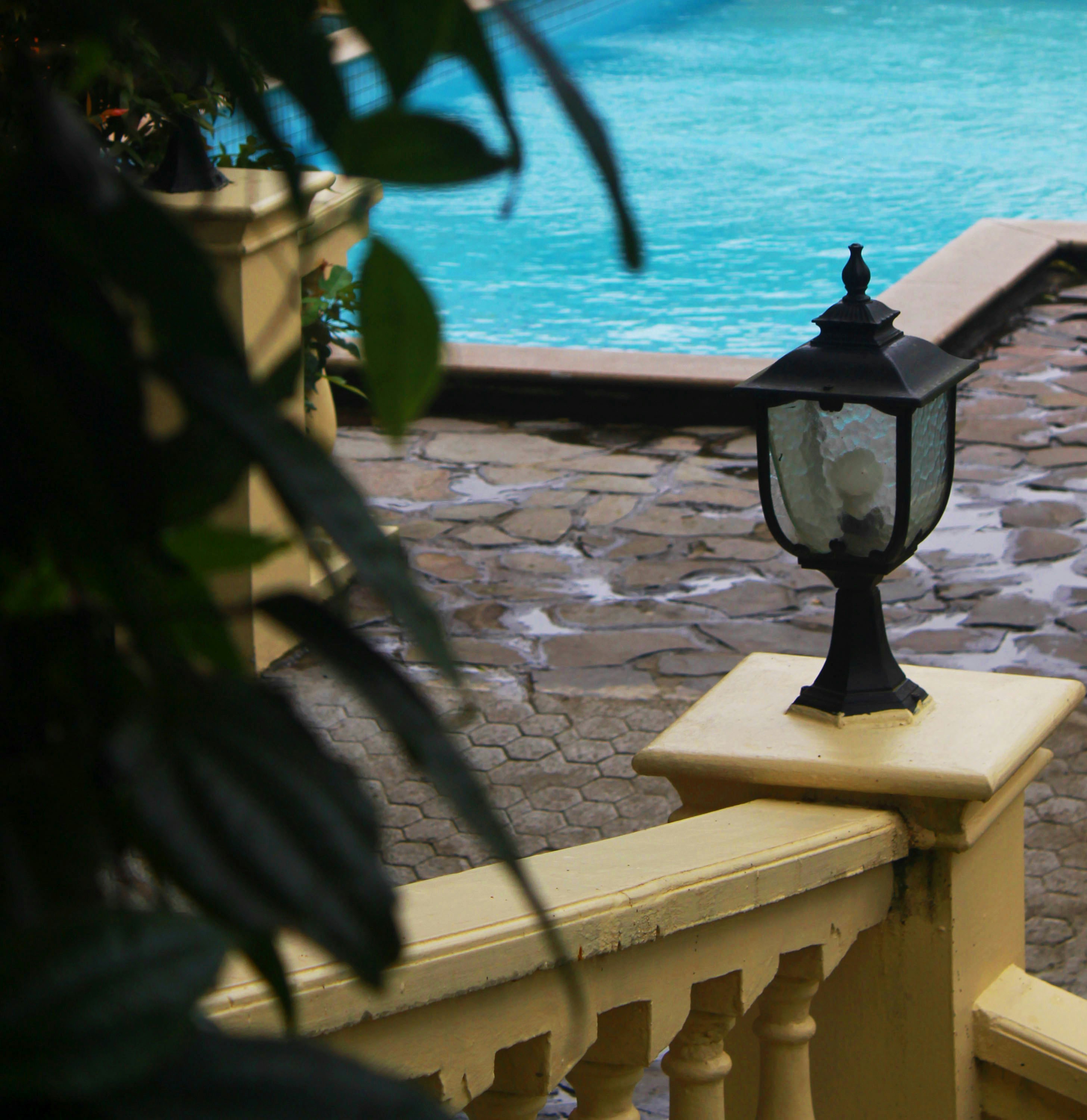 A lamp on a railing next to a pool photo – Free Lamp Image on Unsplash