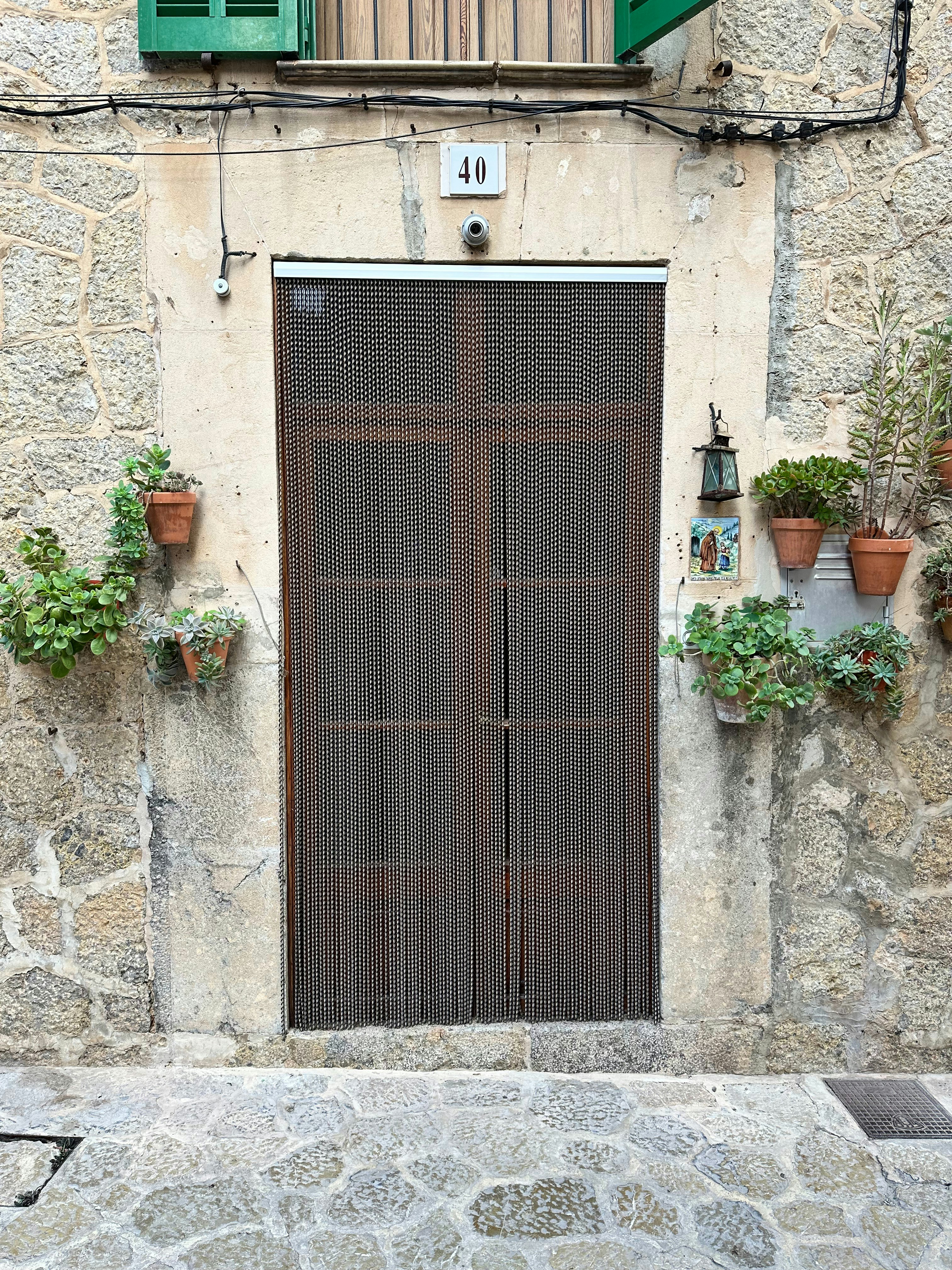 Iron Curtain at a Stone Threshold: A Courtyard Door Framed by Greenery