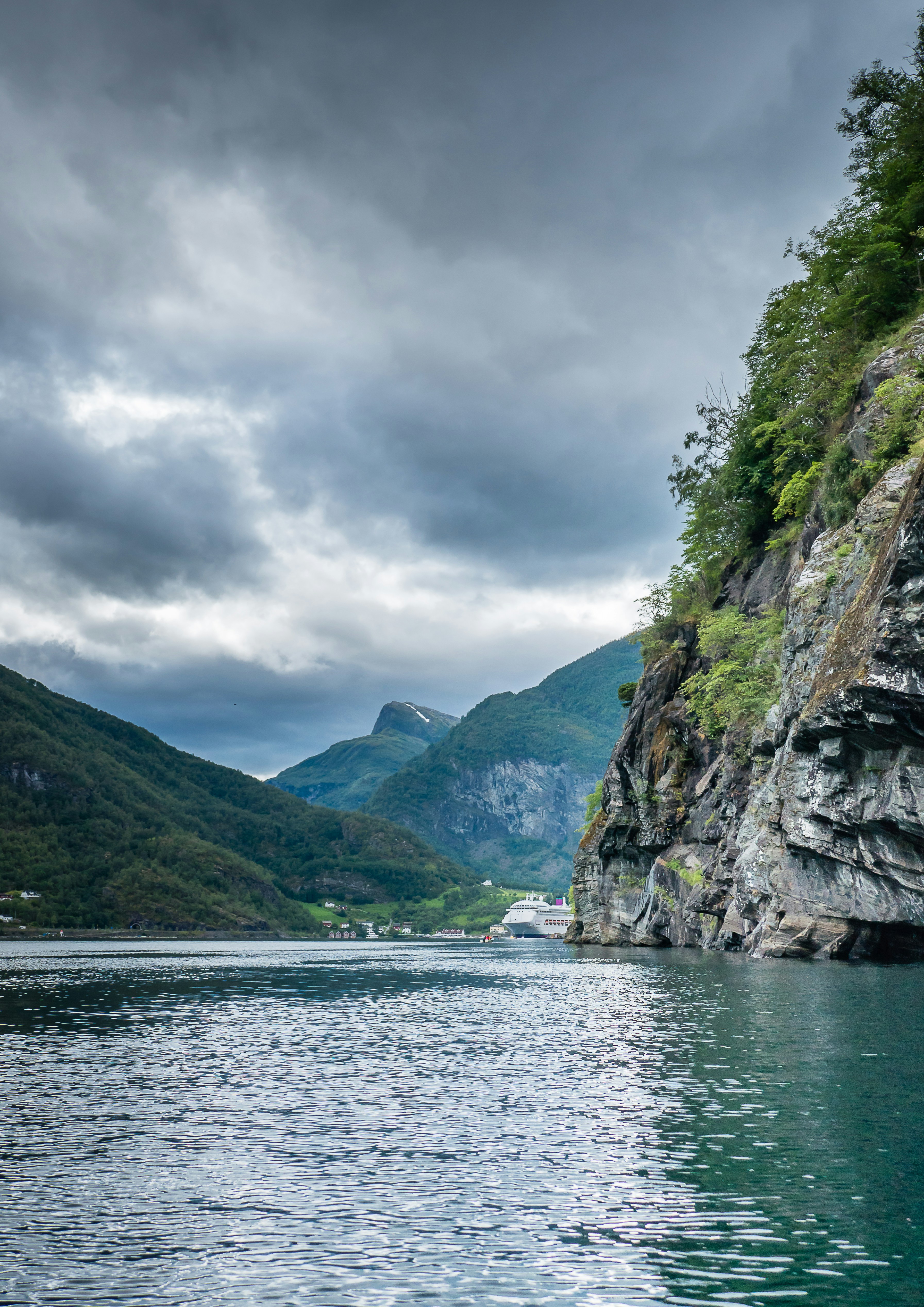 A body of water surrounded by mountains under a cloudy sky photo – Free ...