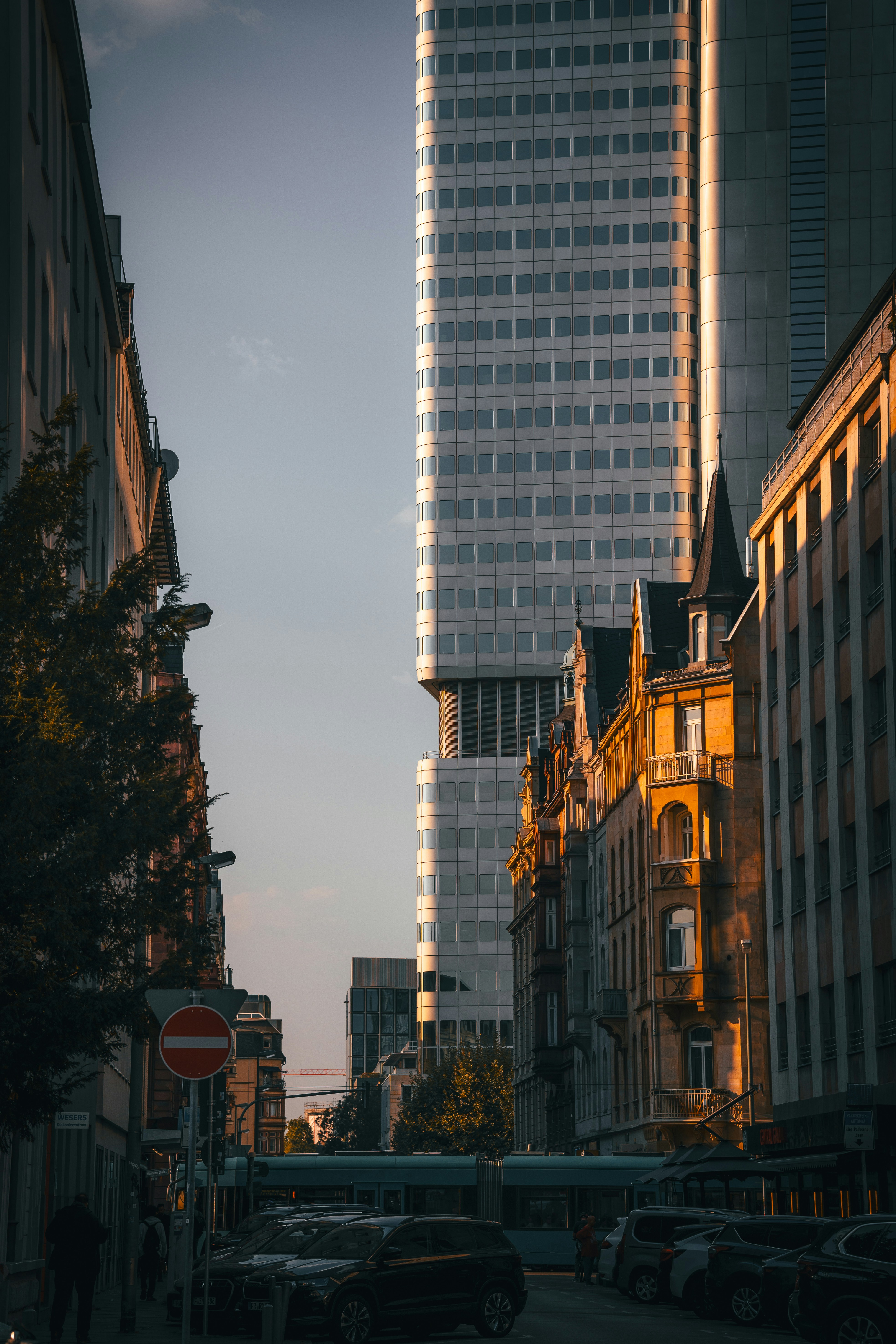 Glass Spire Over a Historic Street at Golden Hour