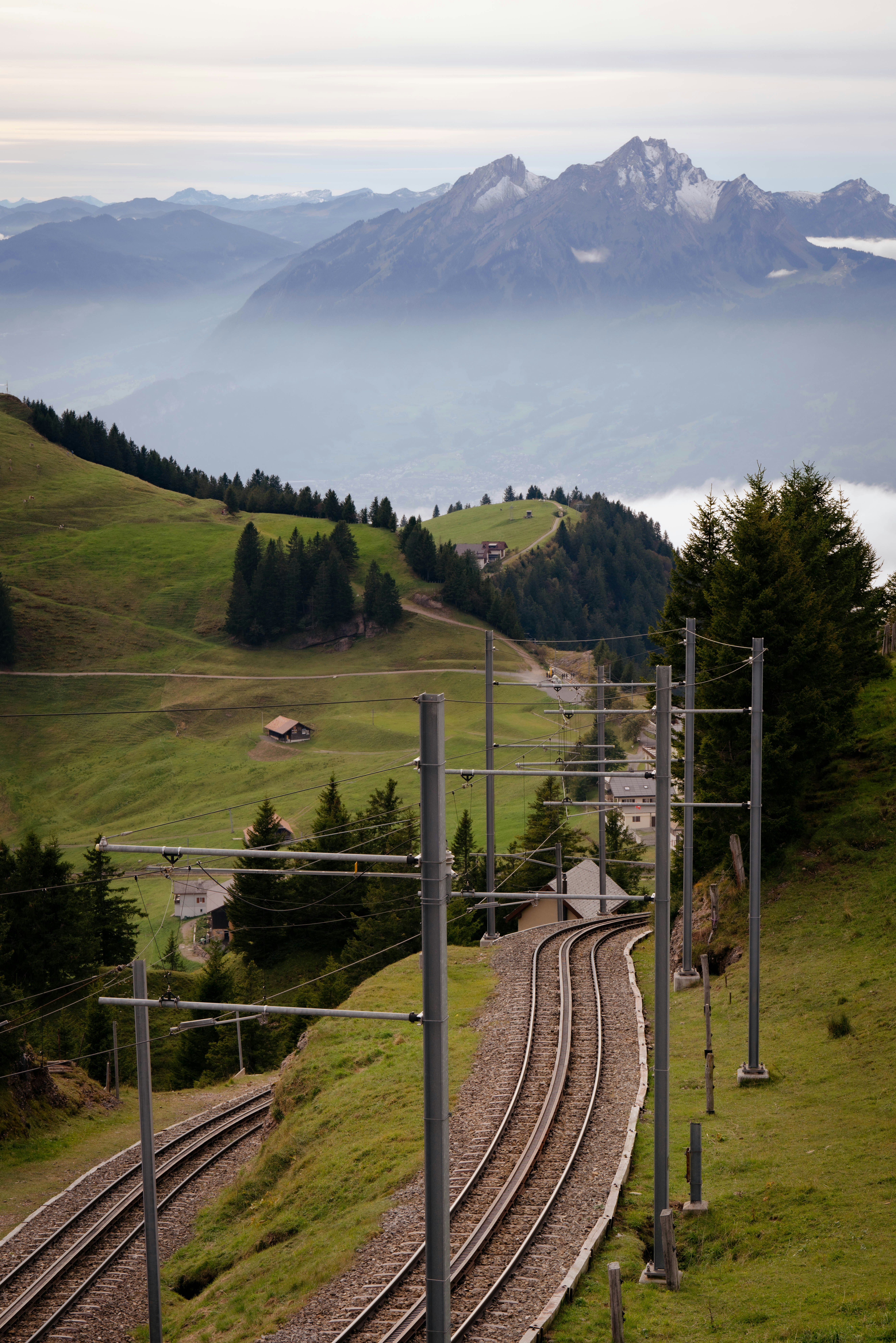 Alpine Rail Curve Toward a Misty Mountain Horizon